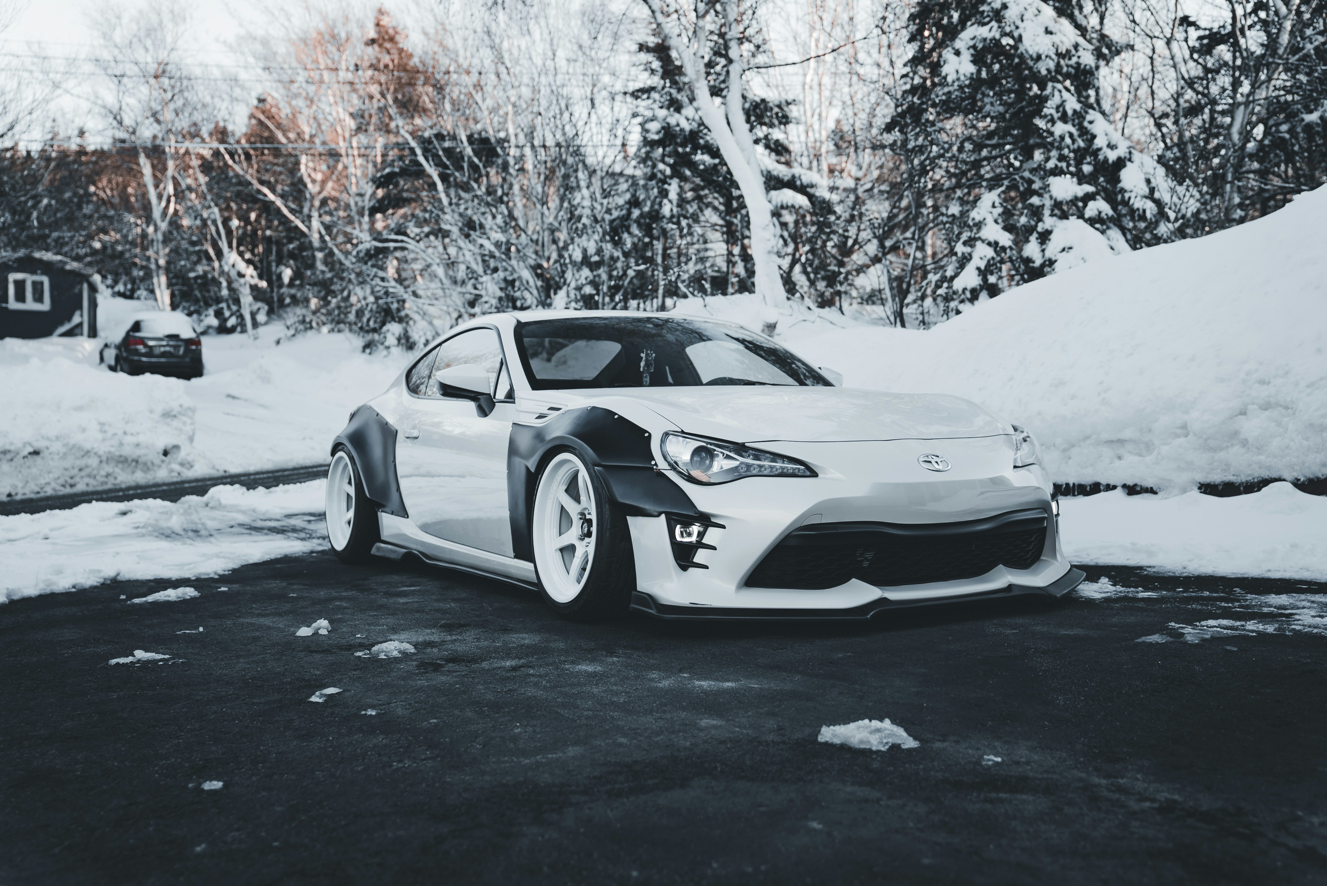 White Sports Coupe Emerges from Snowy Backdrop