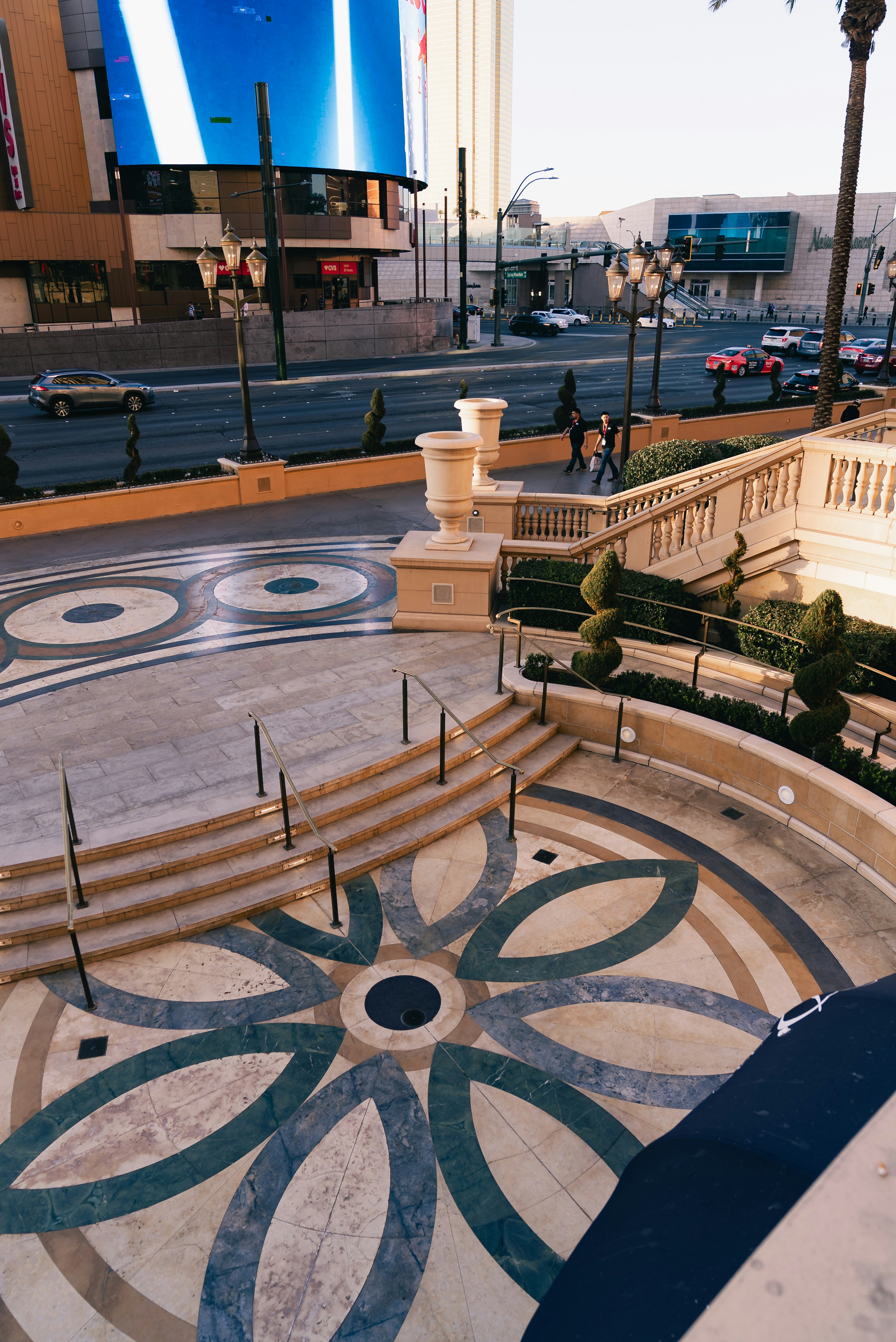 Architectural Piazza: Circular Mosaic and Grand Staircase Framed by Urban Street Scene
