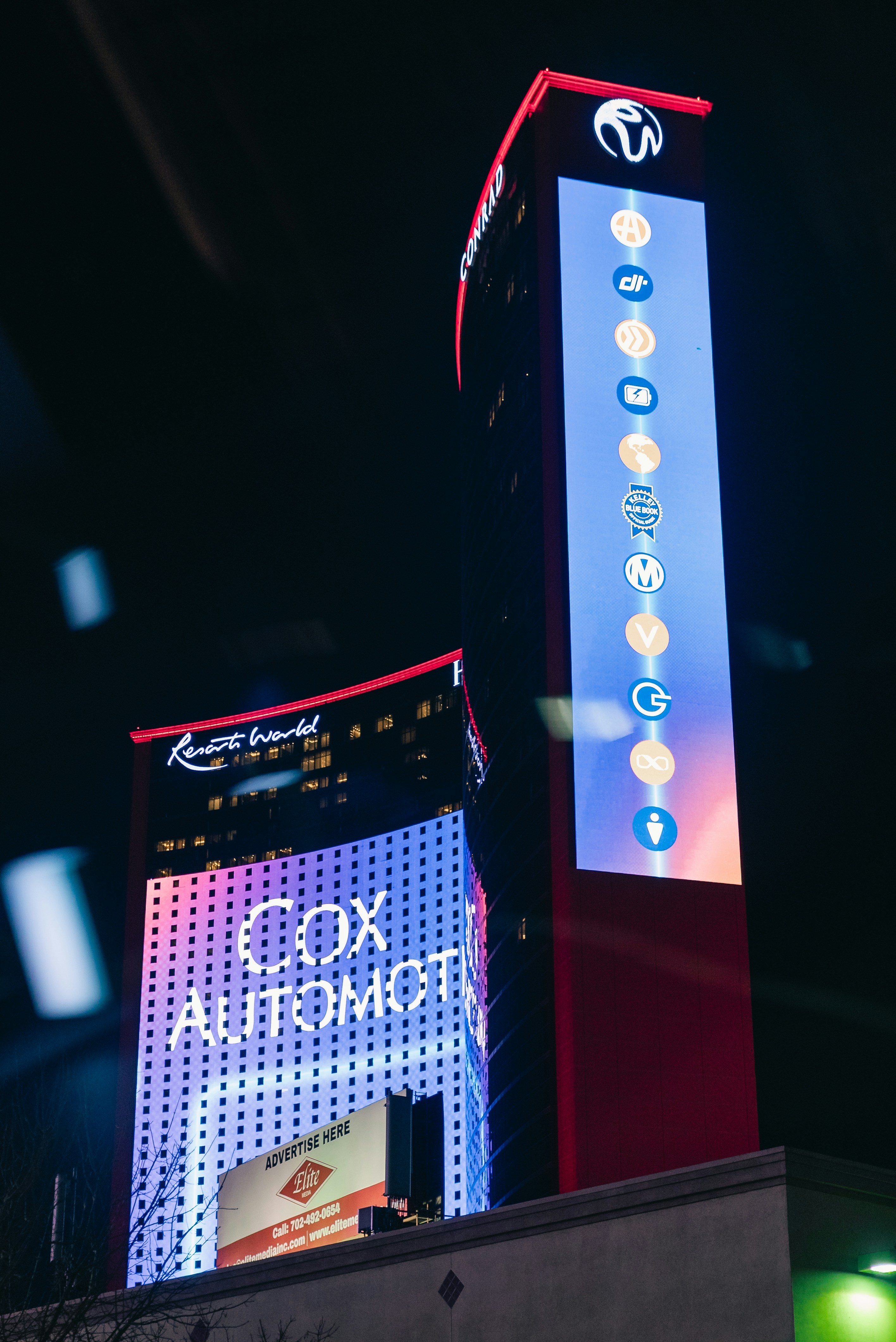 Neon Nexus: Tall Cox AutoCenter Pierces the Night