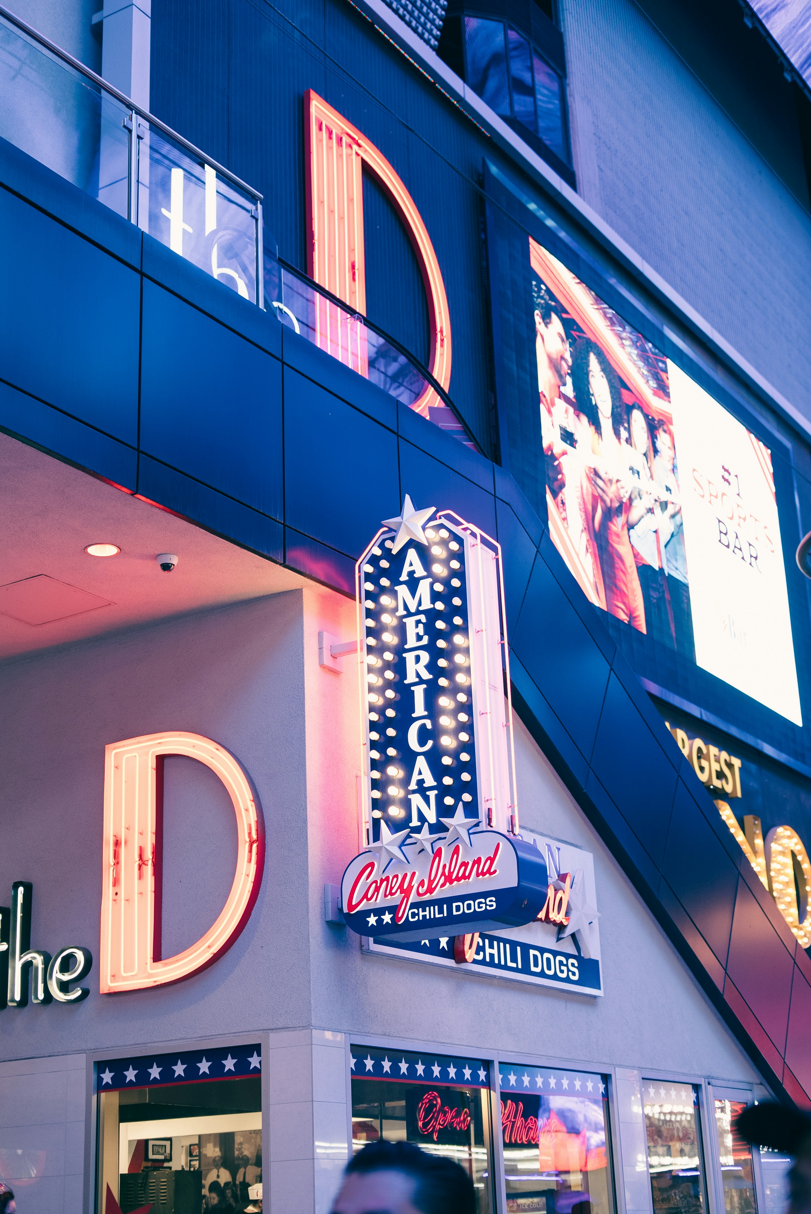 Neon Signage and Digital Billboards Framing Americana on a Busy Street