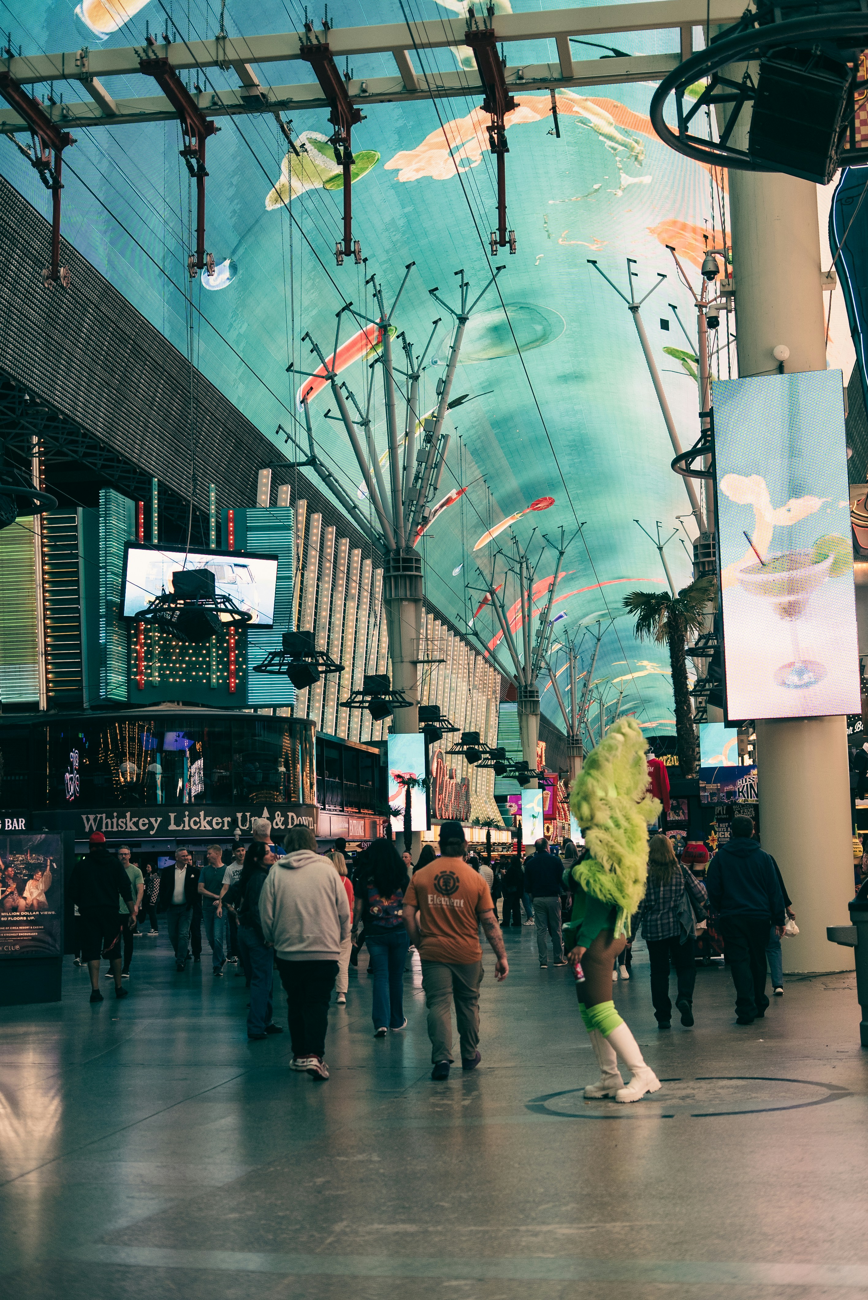 People walking under a vibrant led screen canopy