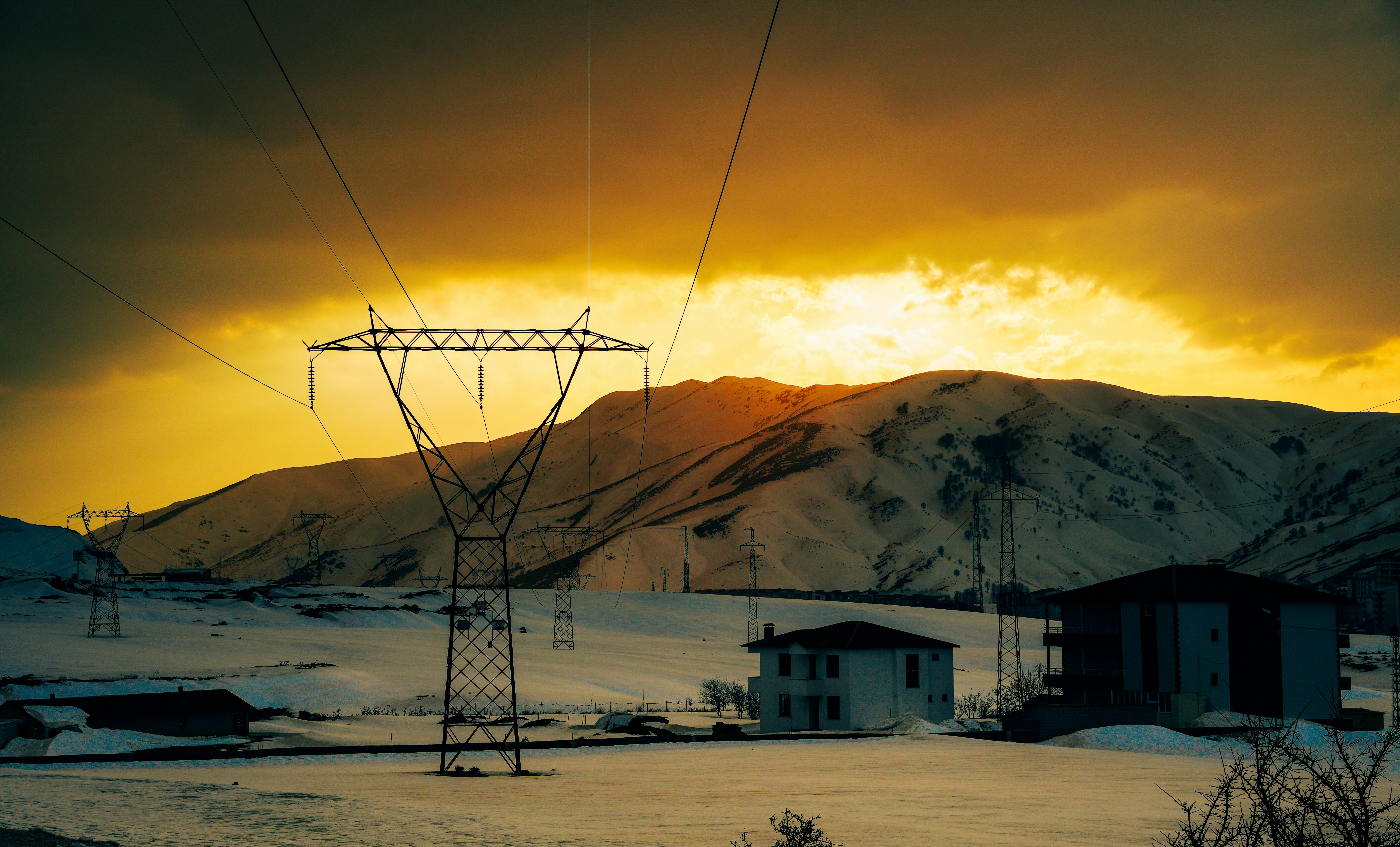 Sunlit Slope and Power Lines Over a Snow-Scaped Village