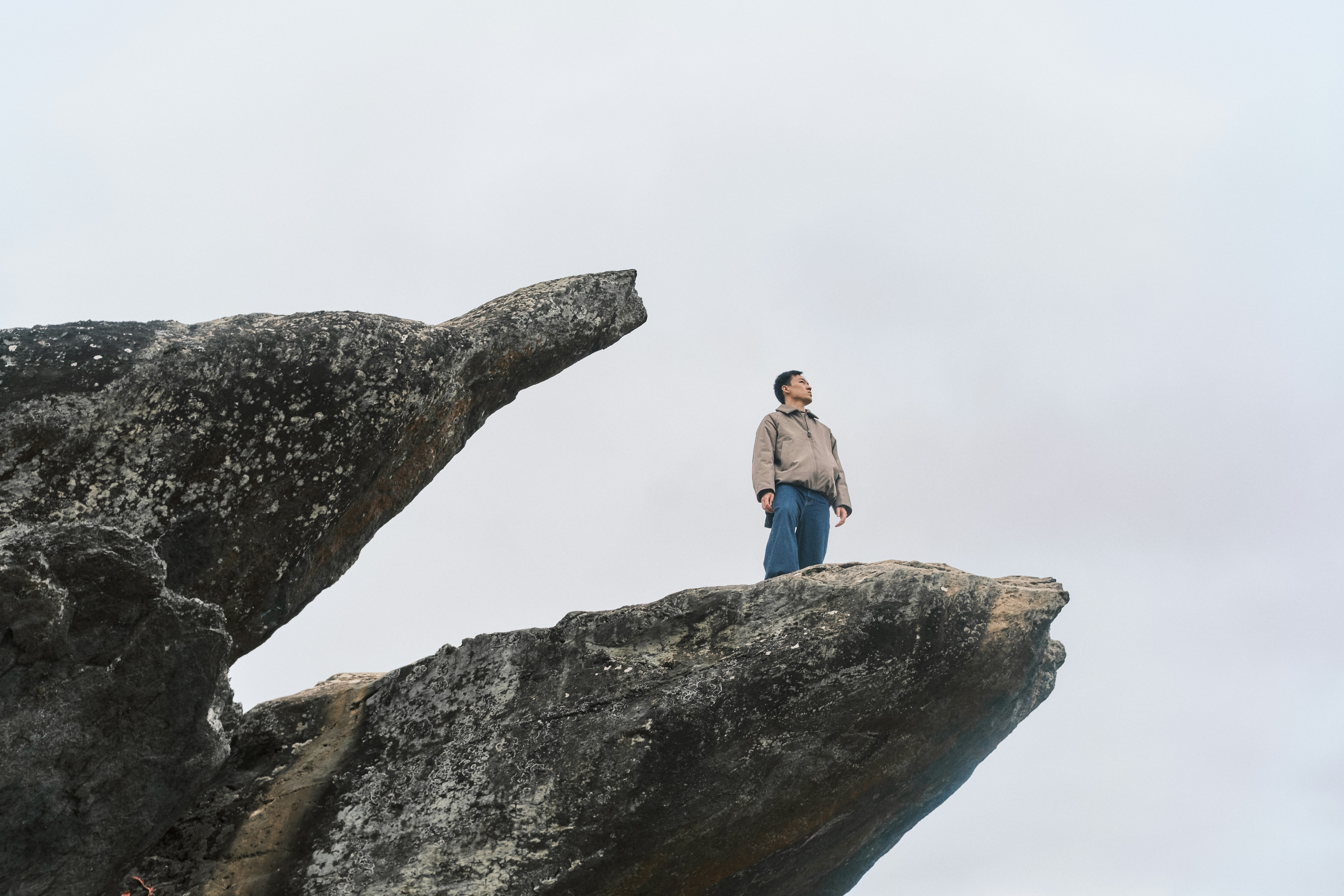 Edge of the World: A solitary climber poised on a jagged cliff