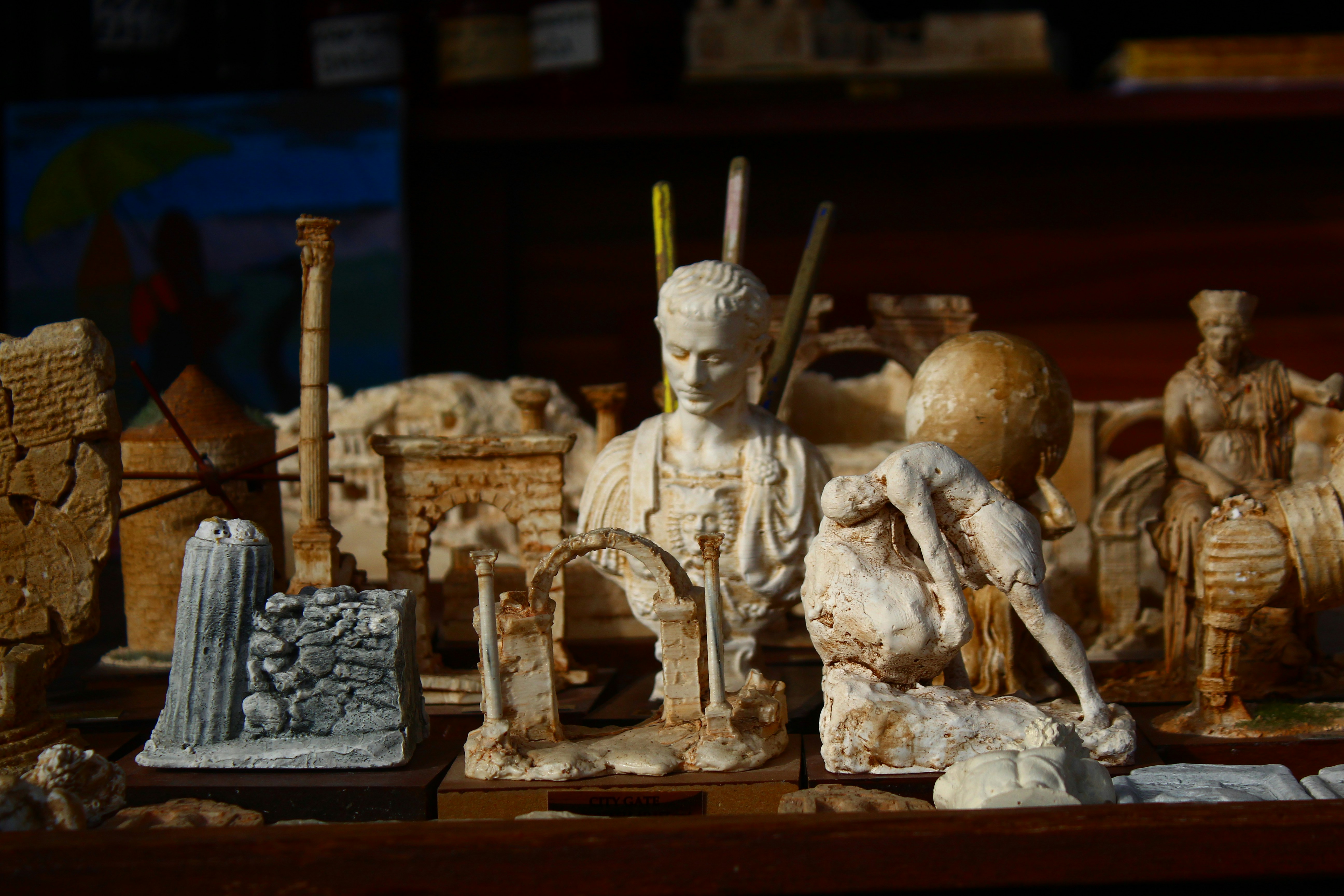 Miniature Studio: A Shelf of Ancient Figurines in Warm Spotlight