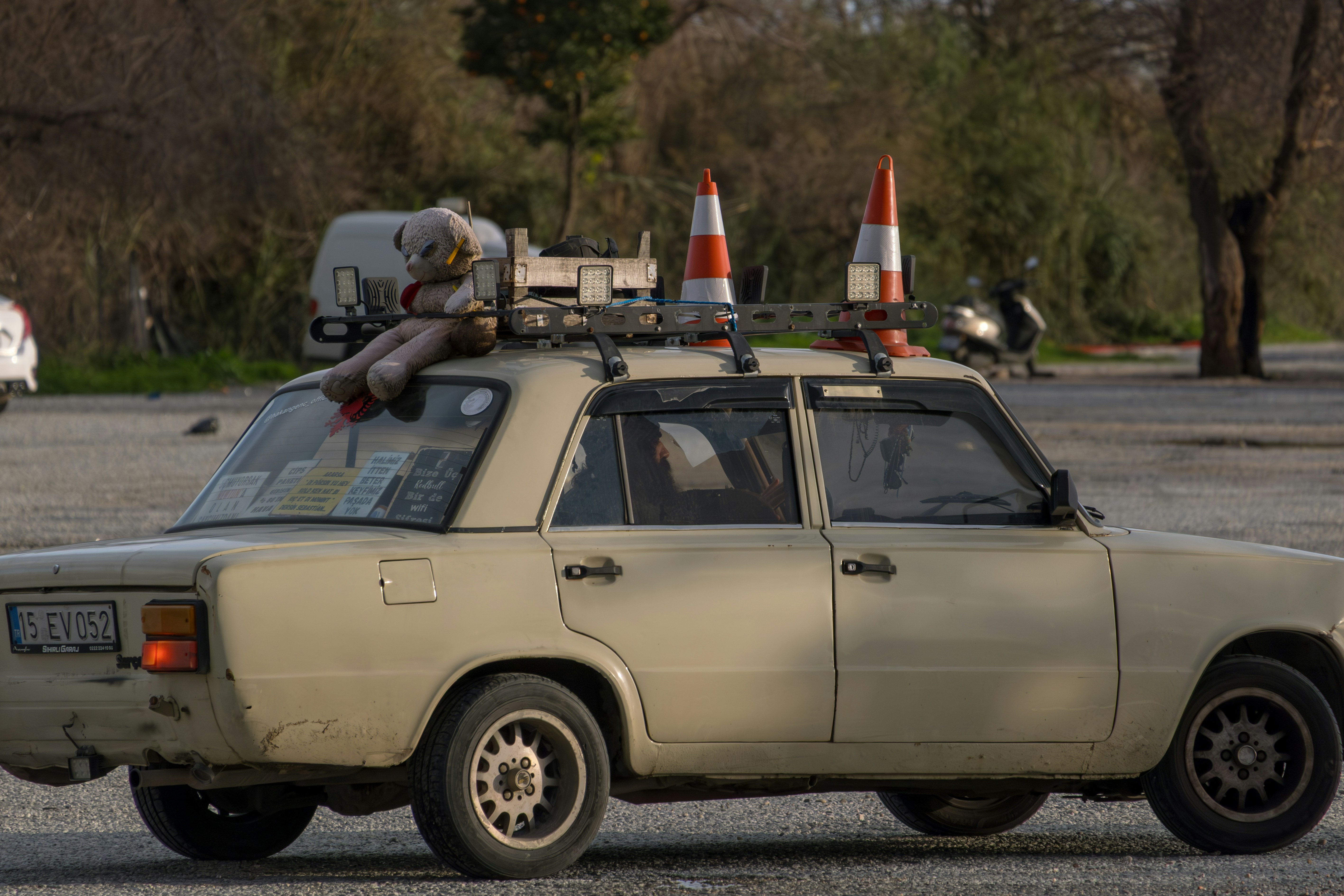Road-tripped relic: a weathered sedan crowned with traffic cones