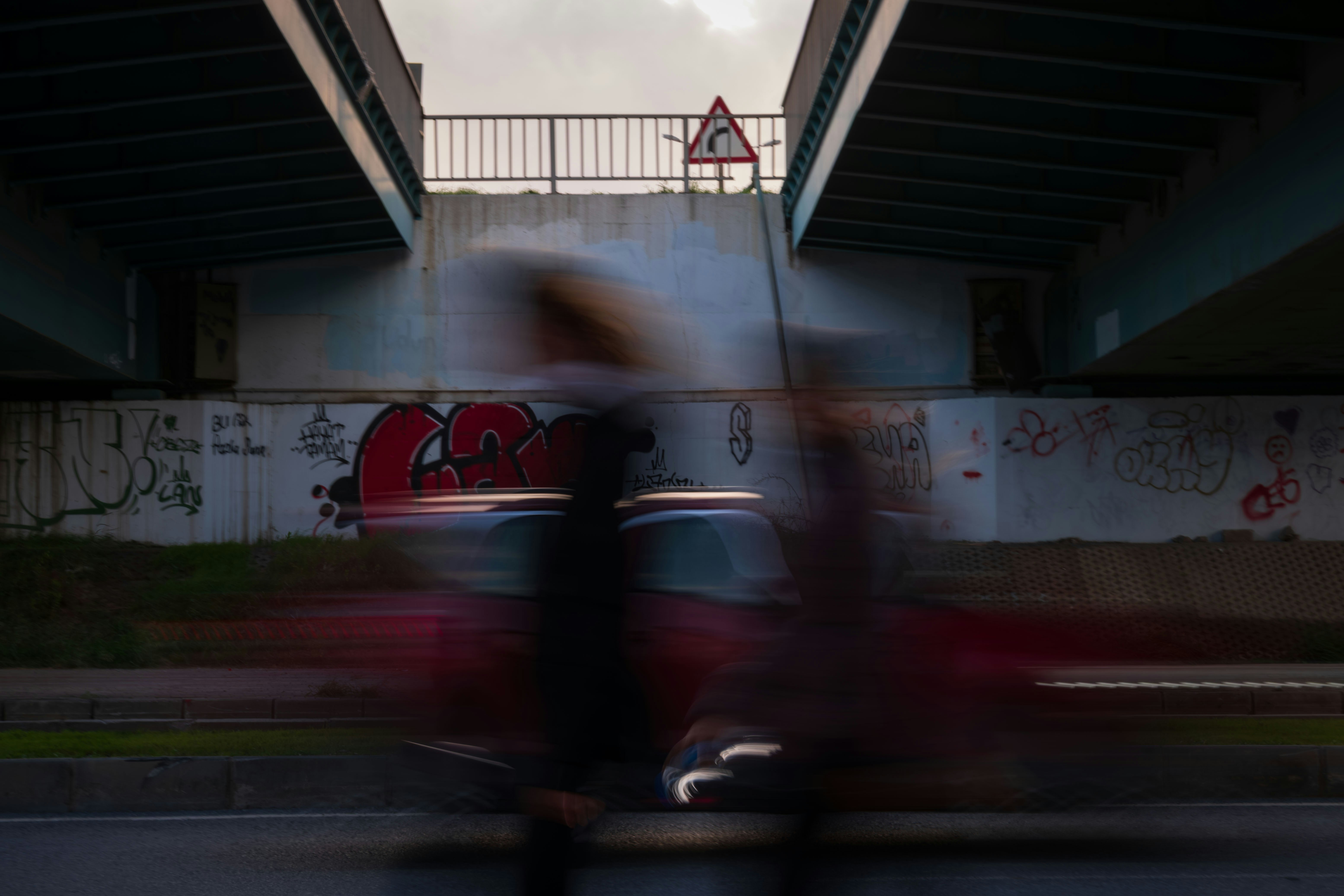 Motion Underpass: Blurred Riders in a Graffitied Corridor