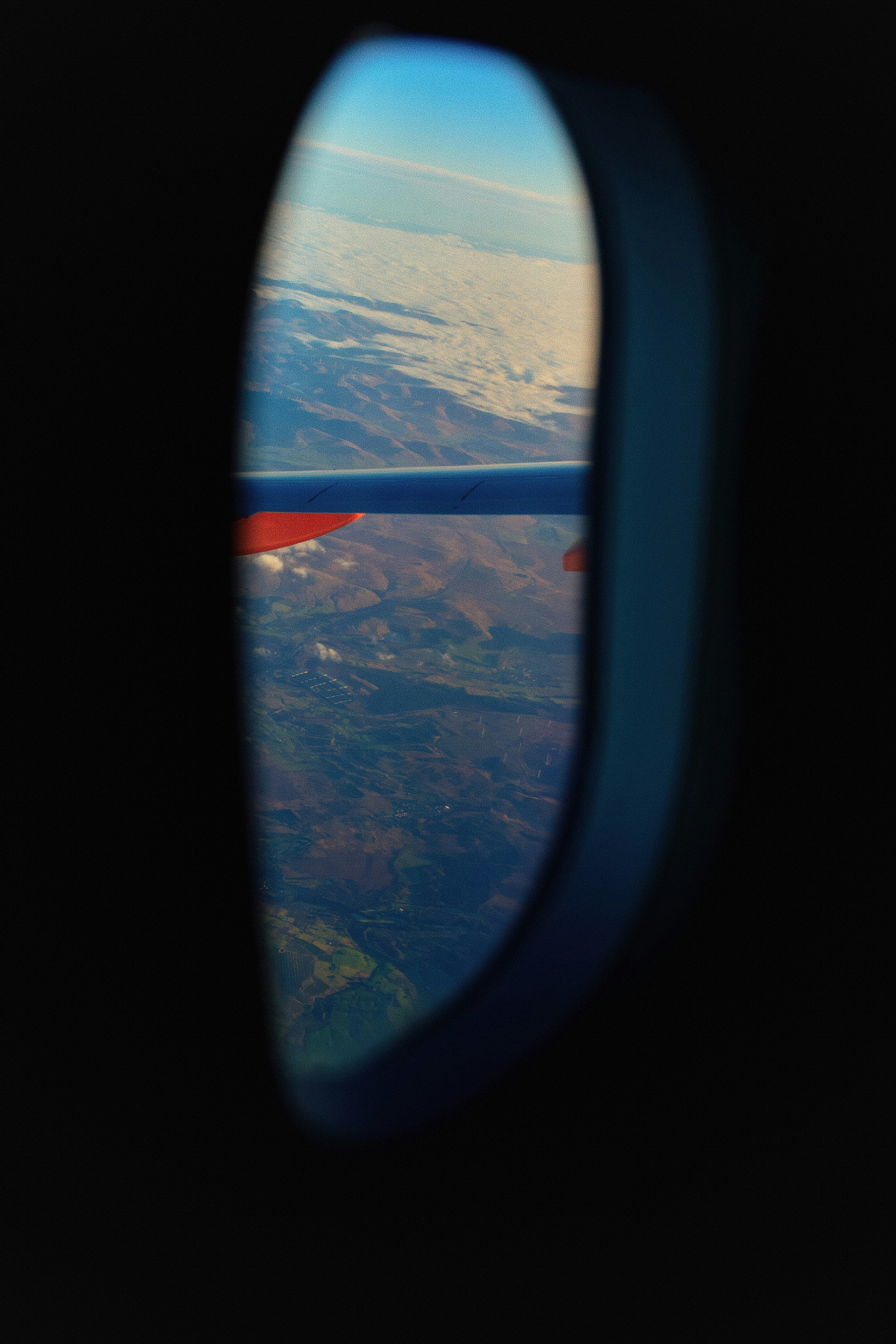 Flight Window View: Earthbound Landscape Through a Curved Pane
