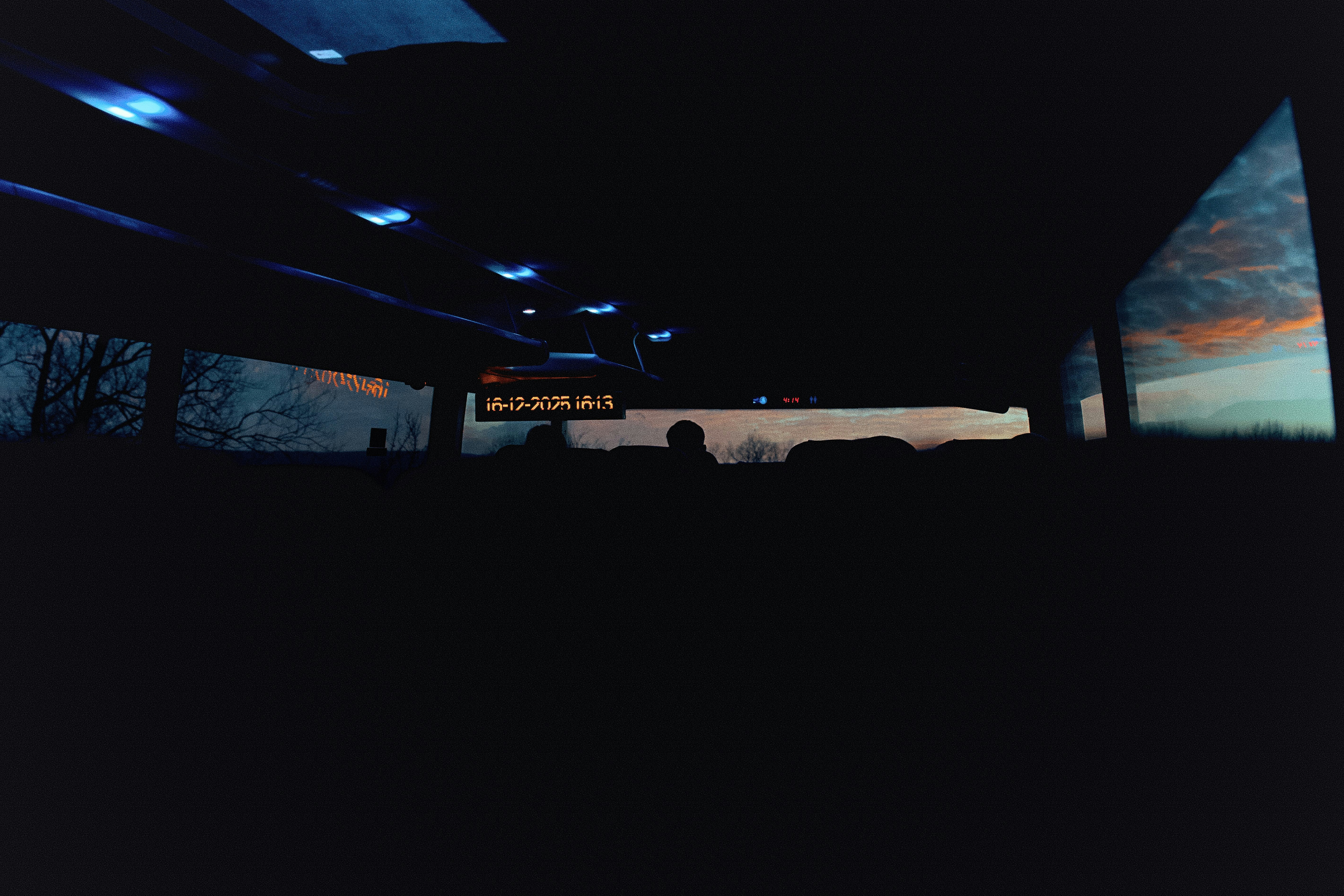 Midnight Bus Window: Blue Neon and Sunset Horizon