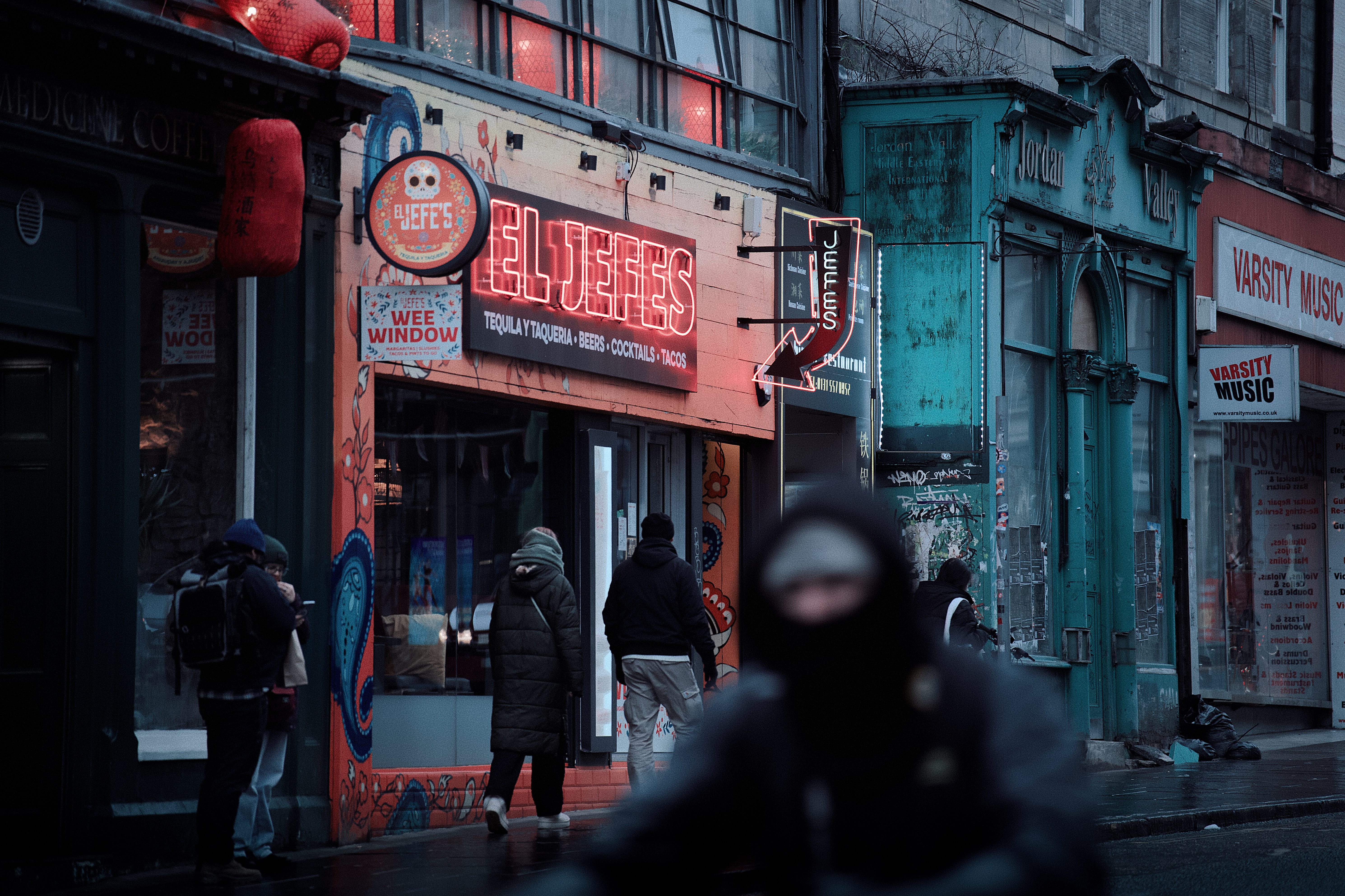 Neon Street Evening: A Blur of Faces and Neon Signage