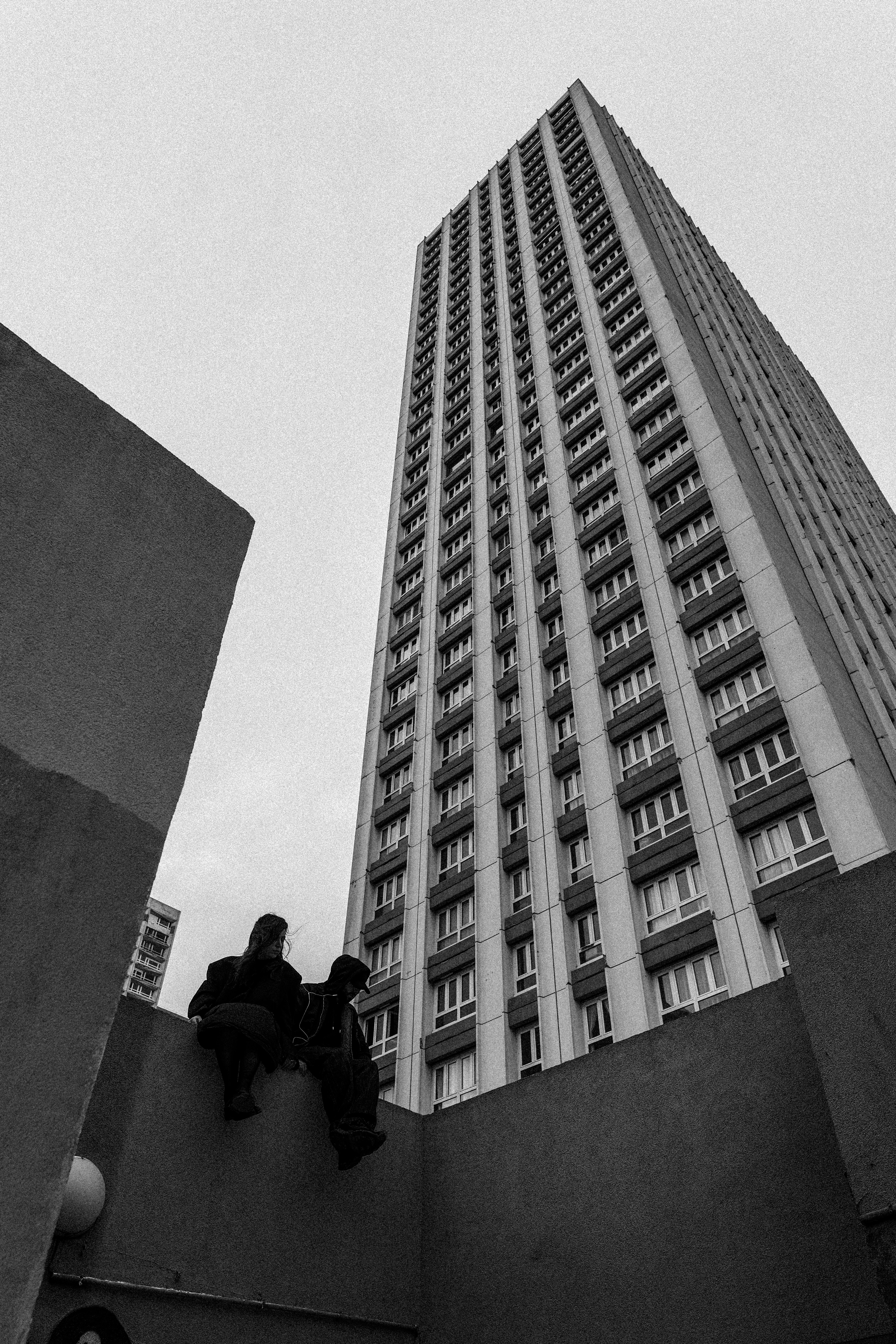 Rooftop Moment: Giants and Shadows Against a City Monolith