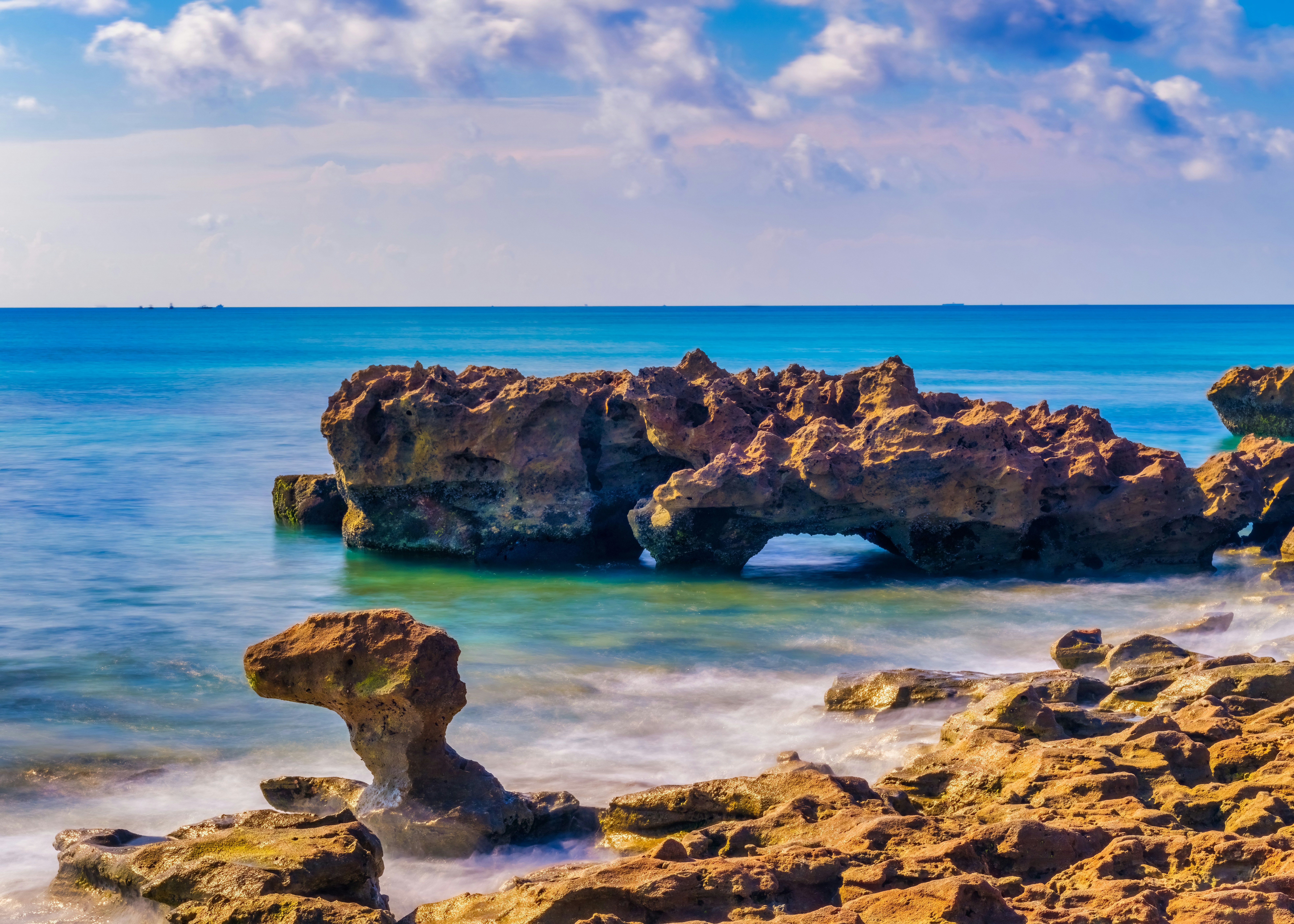 Azure Coastline: Weathered Rocks Framing the Calm Sea