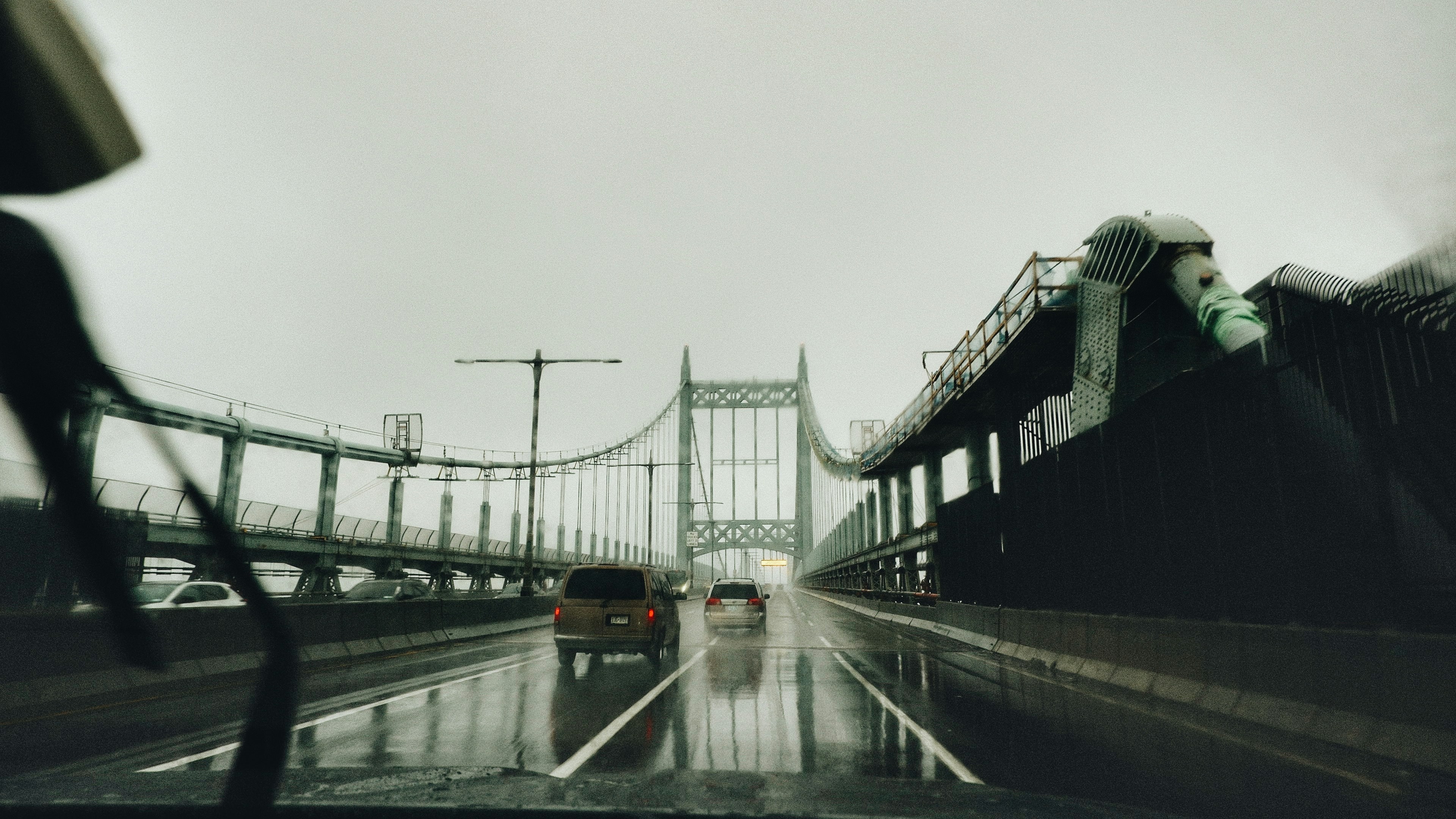 Rain-Slick River Crossing: Cars and Cable-Stayed Bridge in Blur