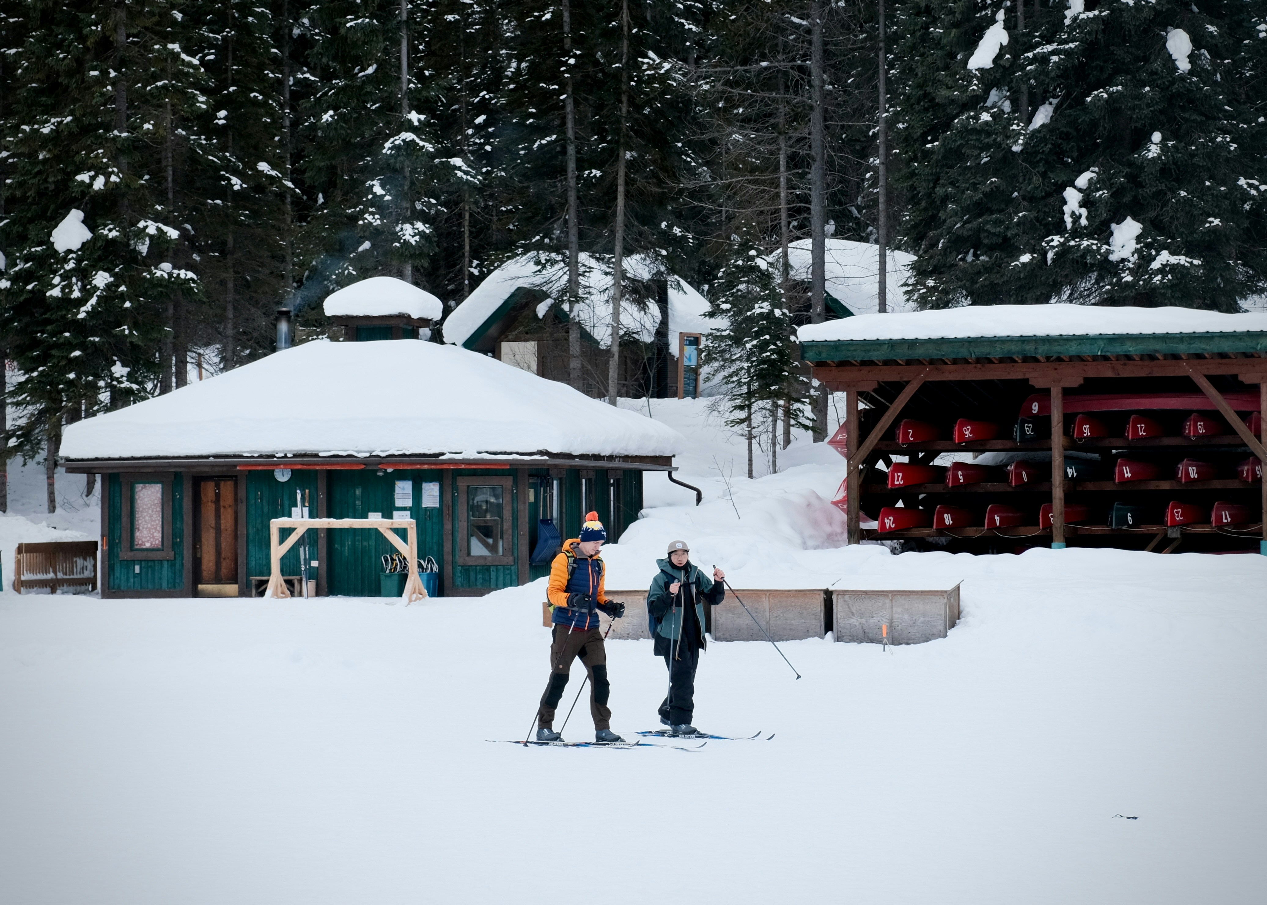Snowbound Guides: Two skiers at a quiet resort between cabins