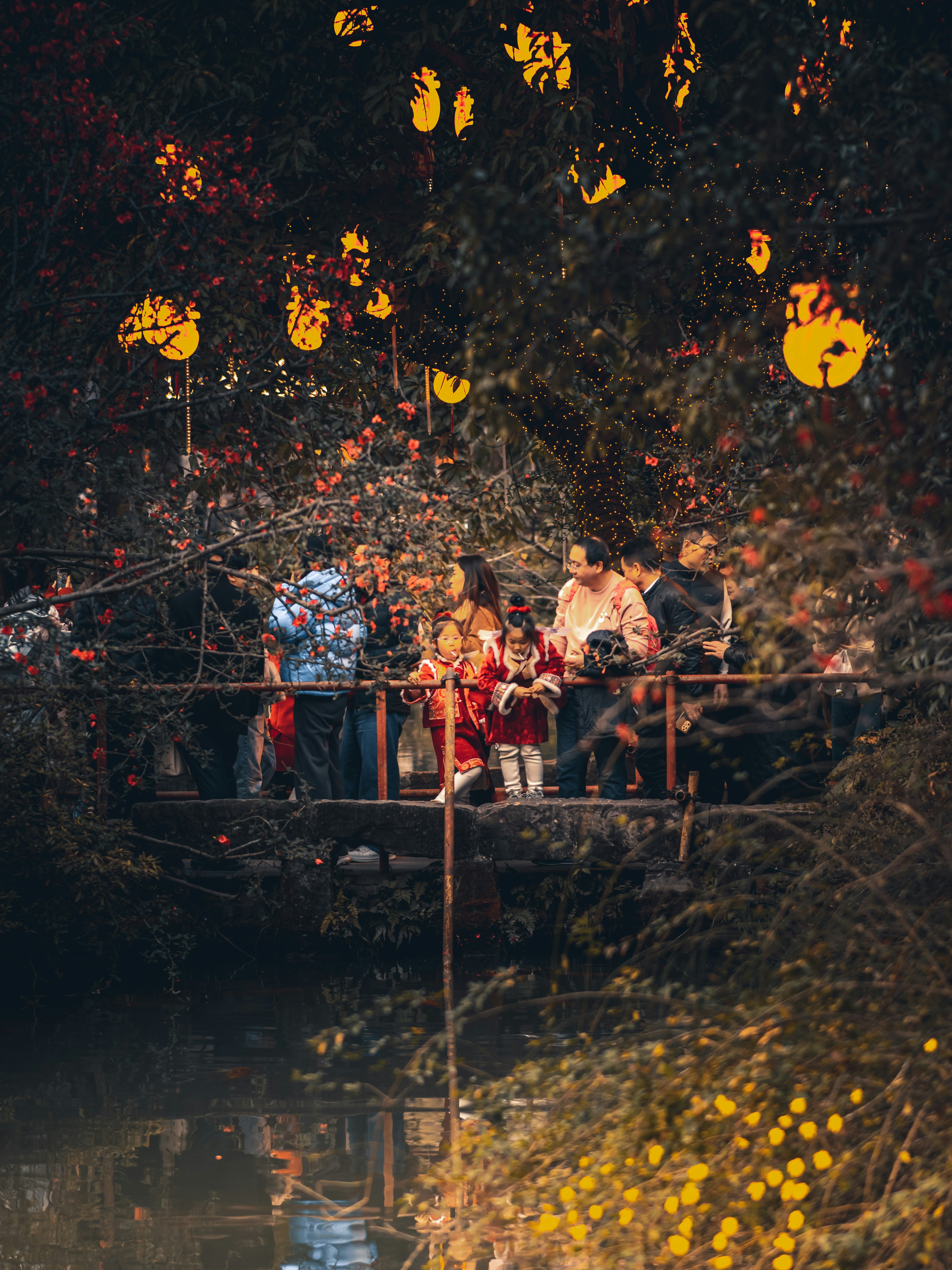 Families and lanterns on a misty bridge