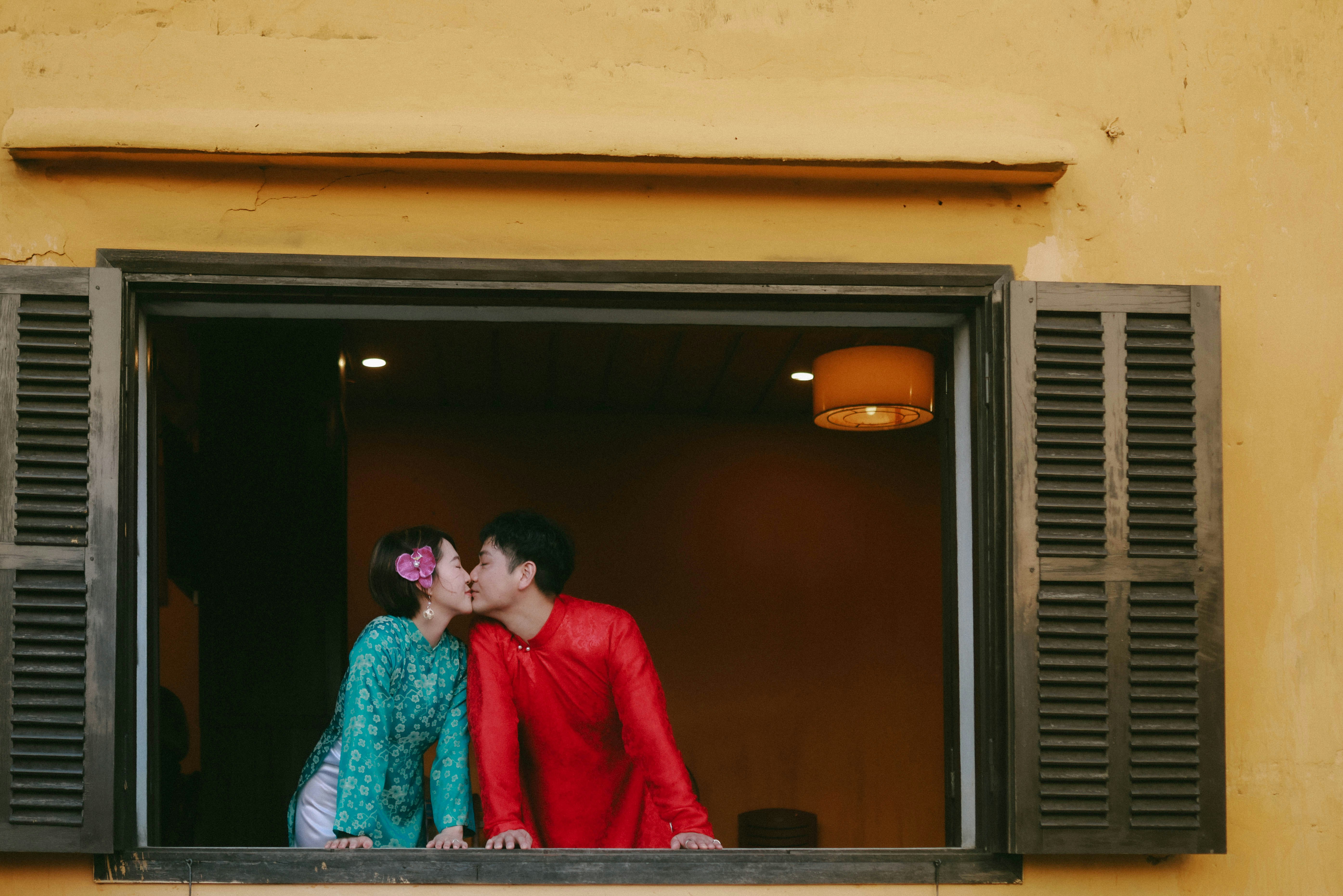 Window kiss in a sunlit courtyard