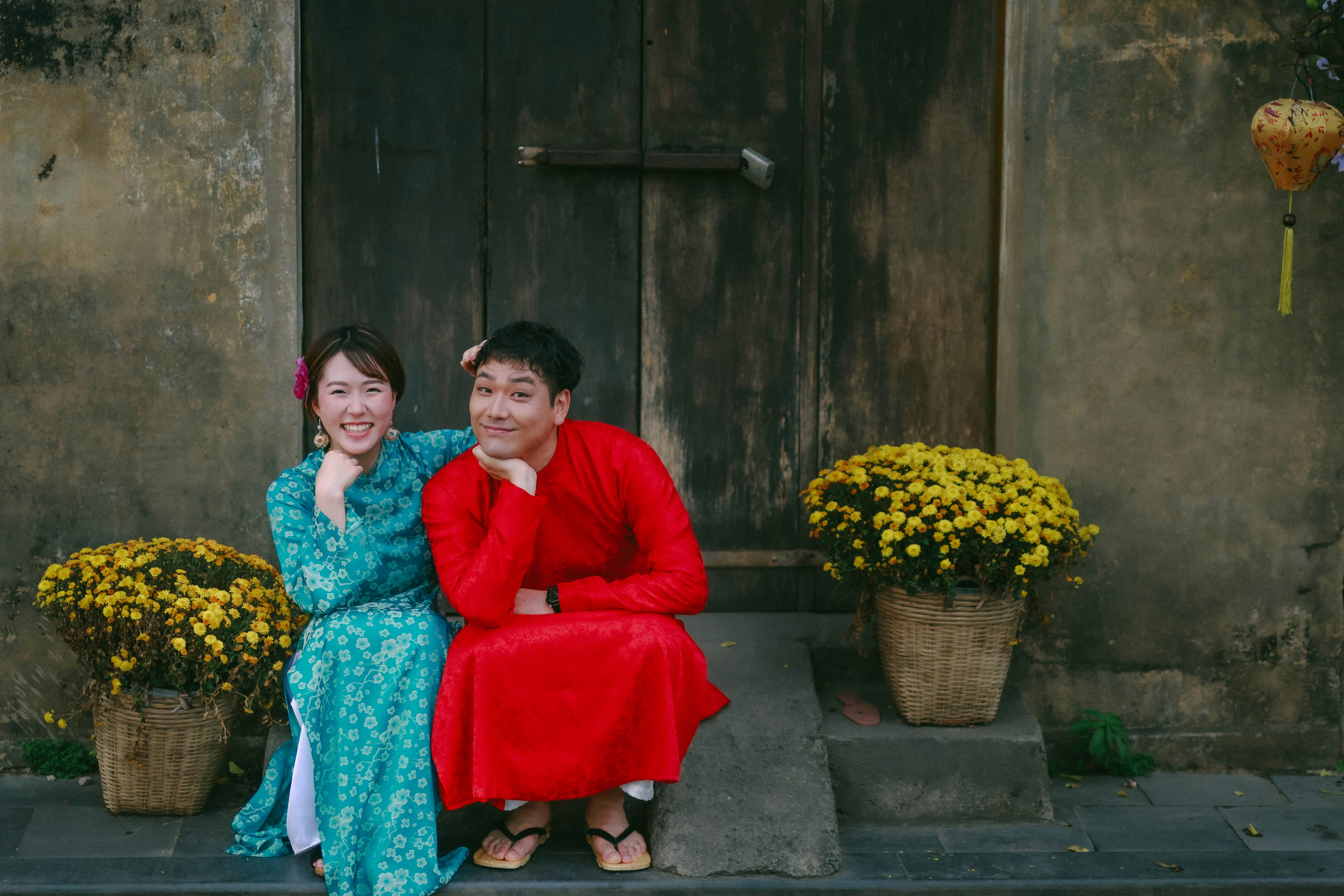 Two Friends in Colorful Attire Beside Yellow Chrysanthemums