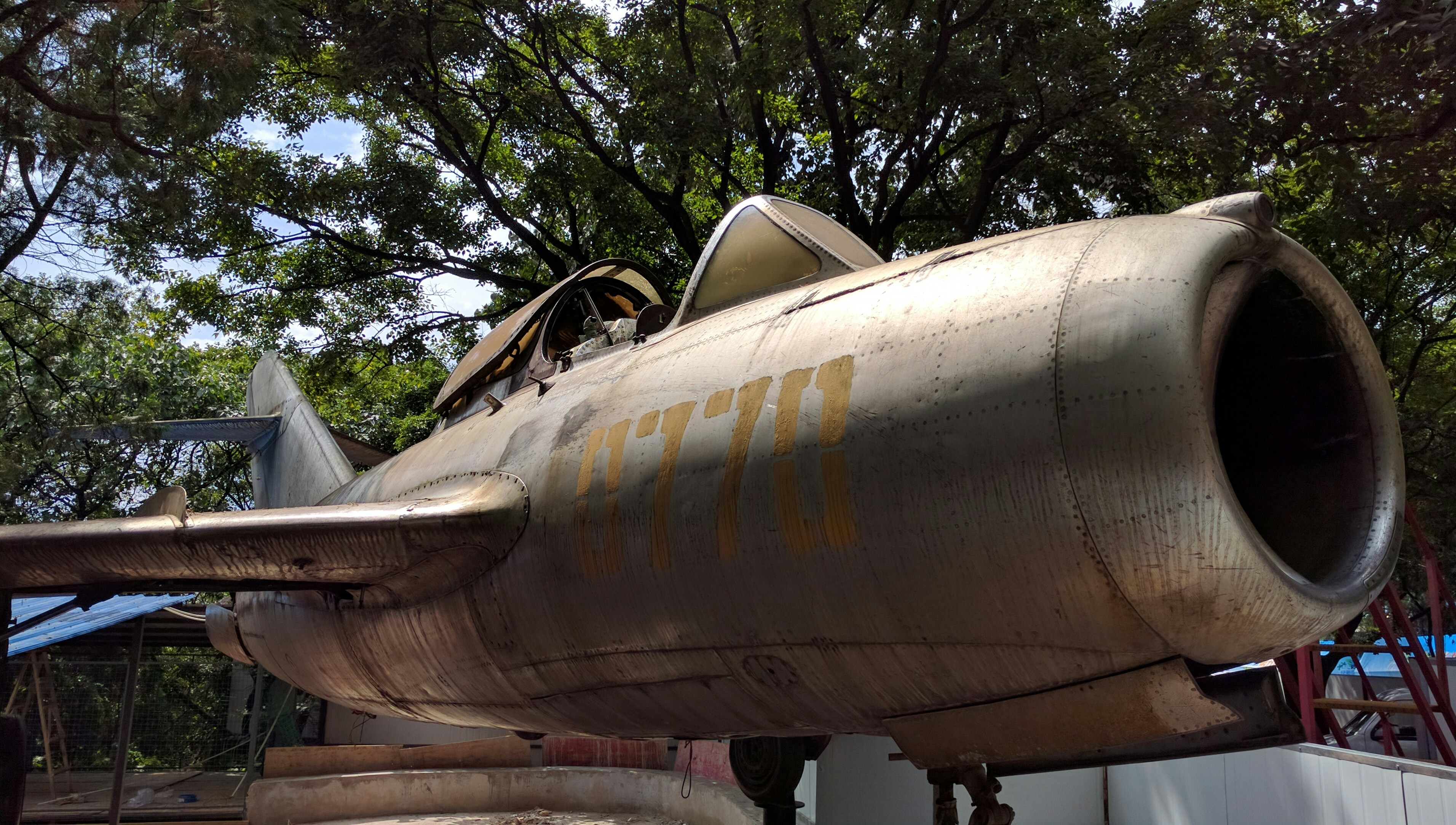 Old fighter jet with faded yellow markings.