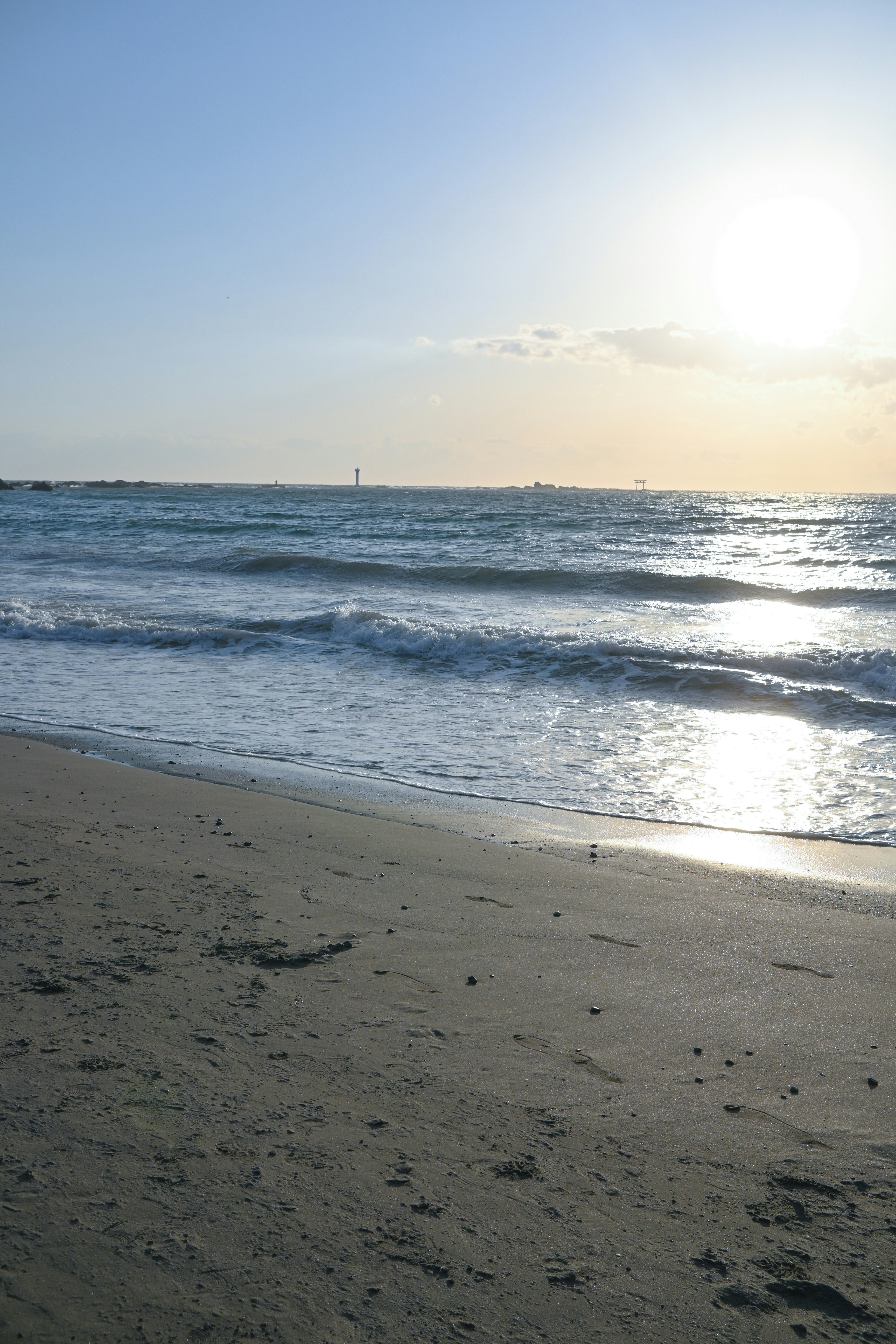 Sunlit Shoreline: Quiet Waves and Distant Horizon