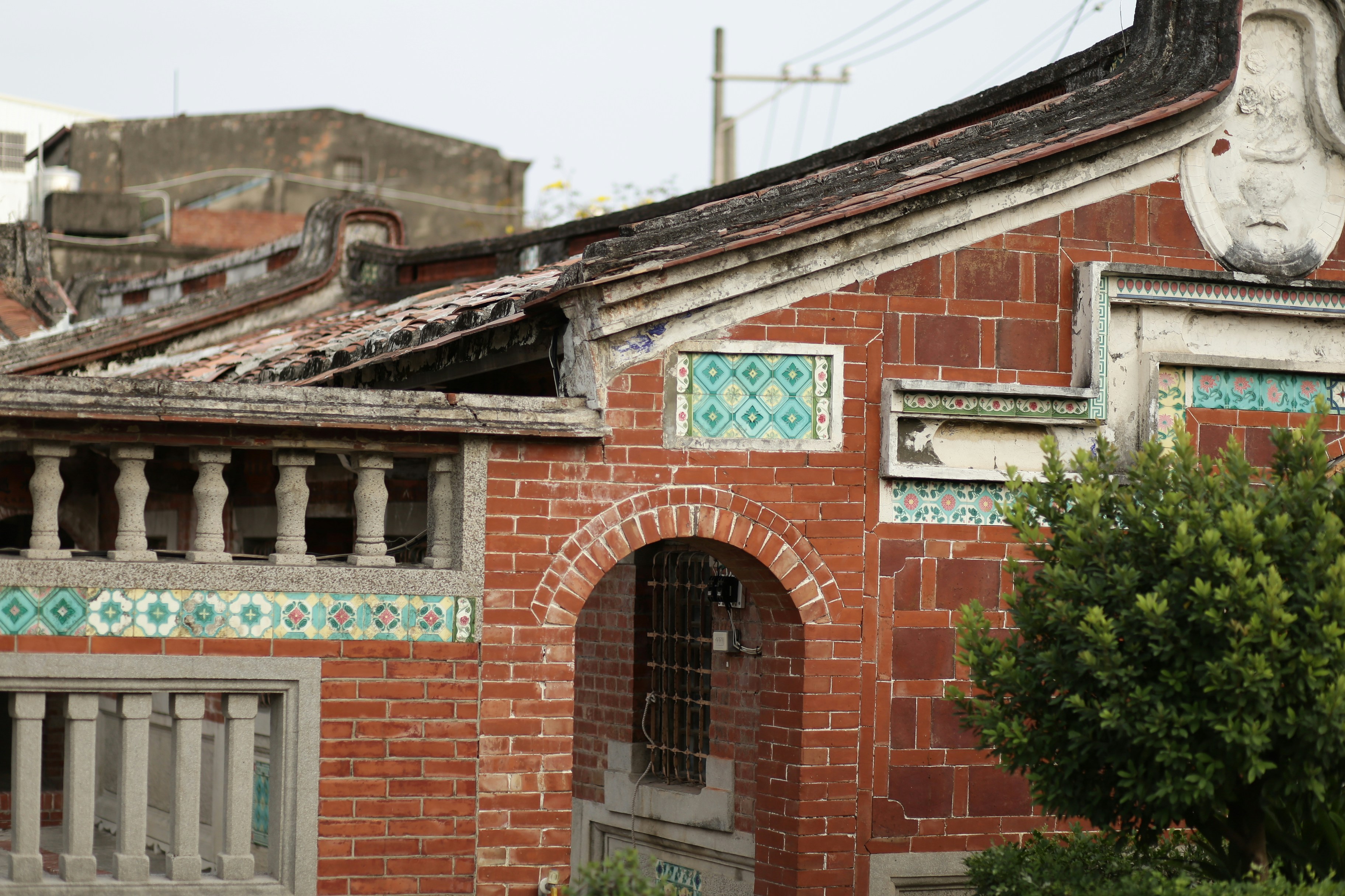 Brick Archway and Ornate Tilework: A Quiet Corner of a Pedimented Structure