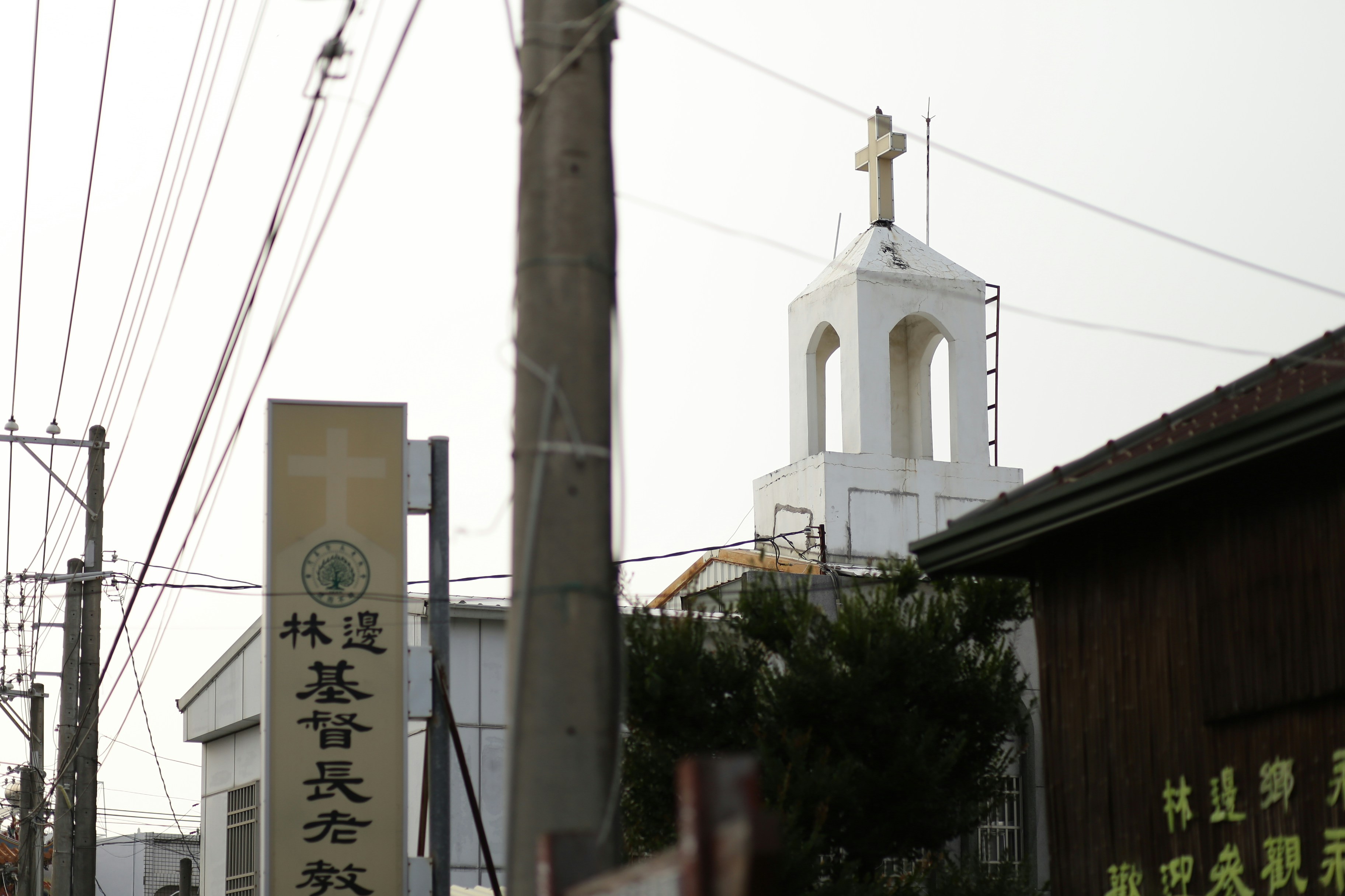 Crossroads of Faith: A White Chapel Tower Framed by Utility Poles