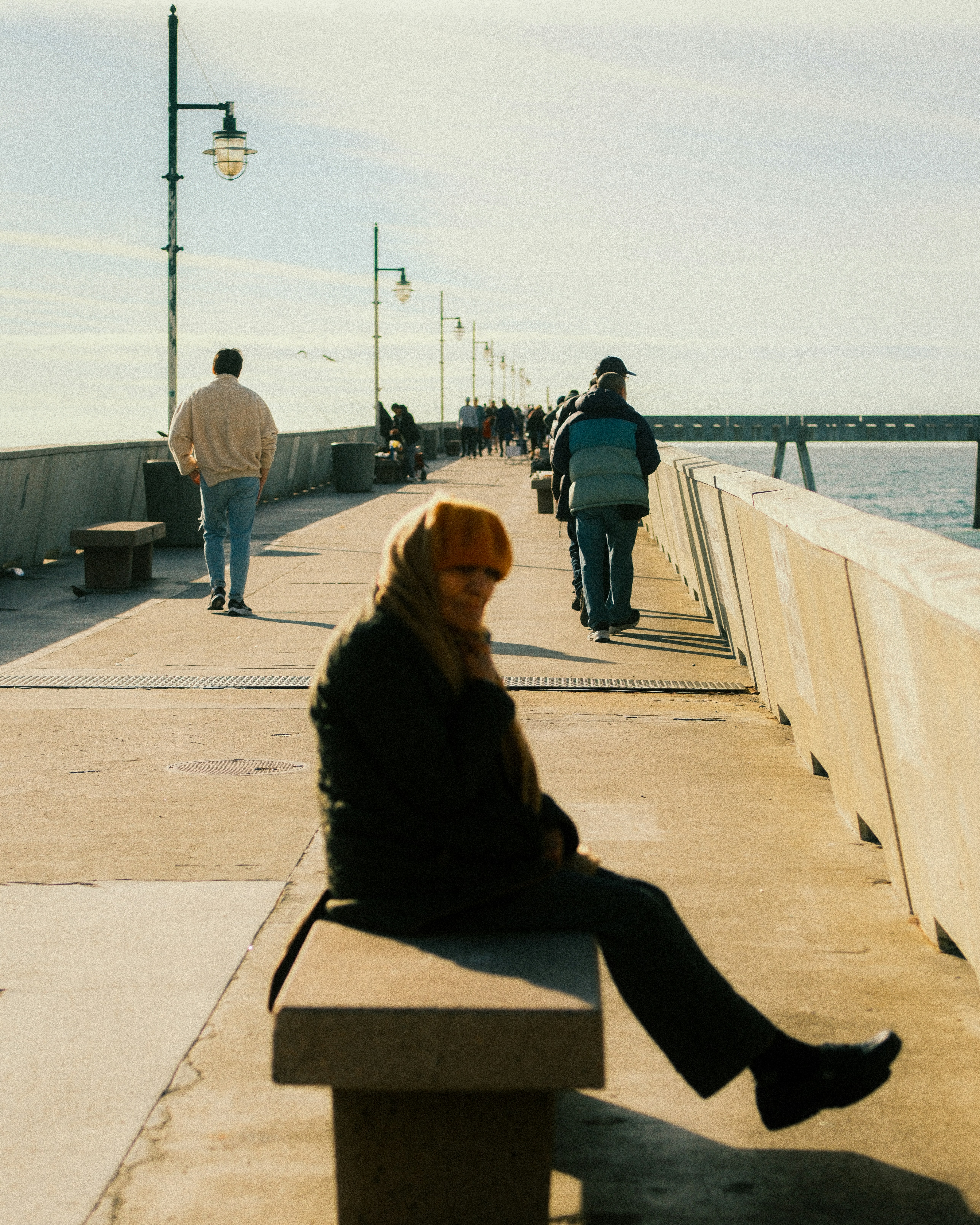 Foreground Figure on a Pier: Quiet Portrait Amidst a Stroll