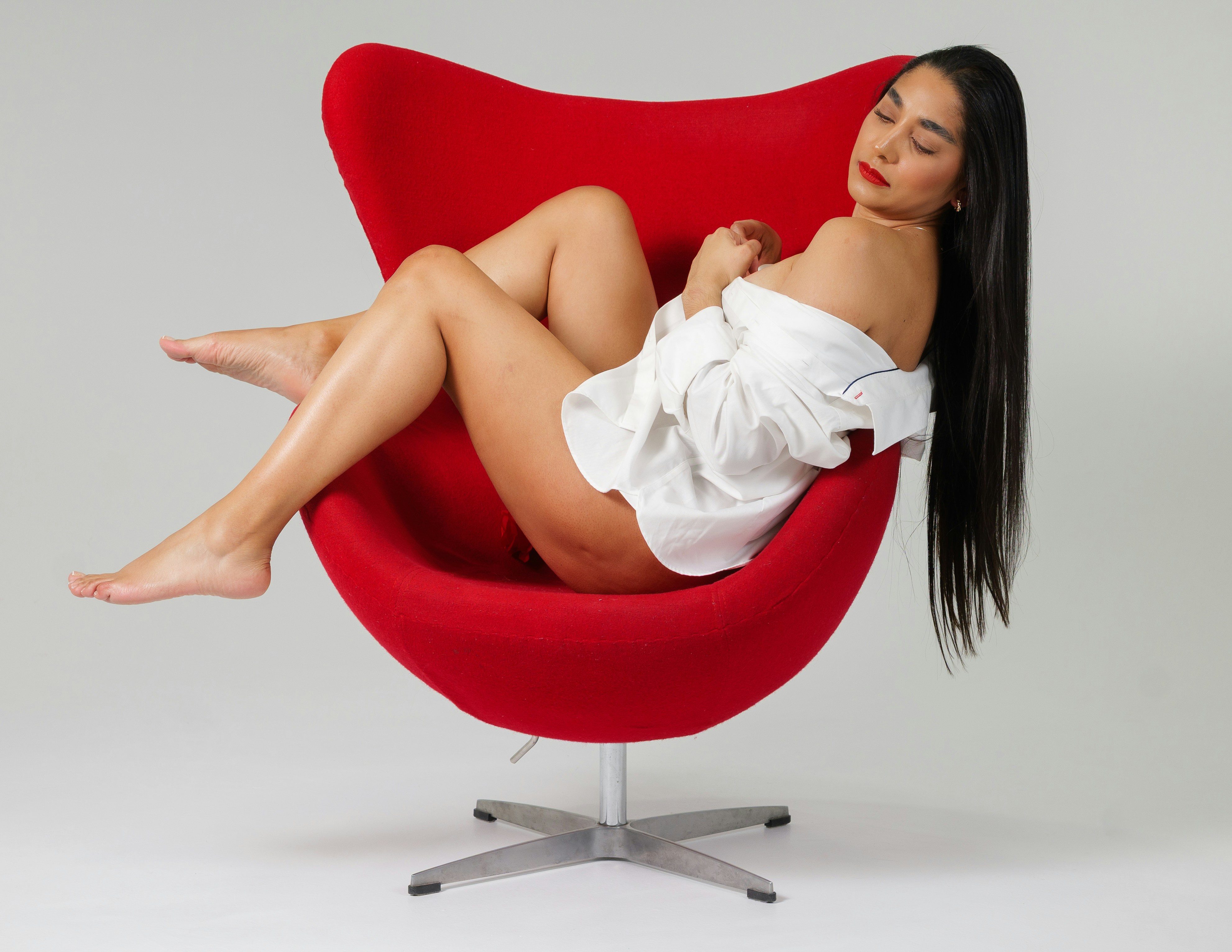 Red Chair Reverie: A Relaxed Pose in a Modern Lounge