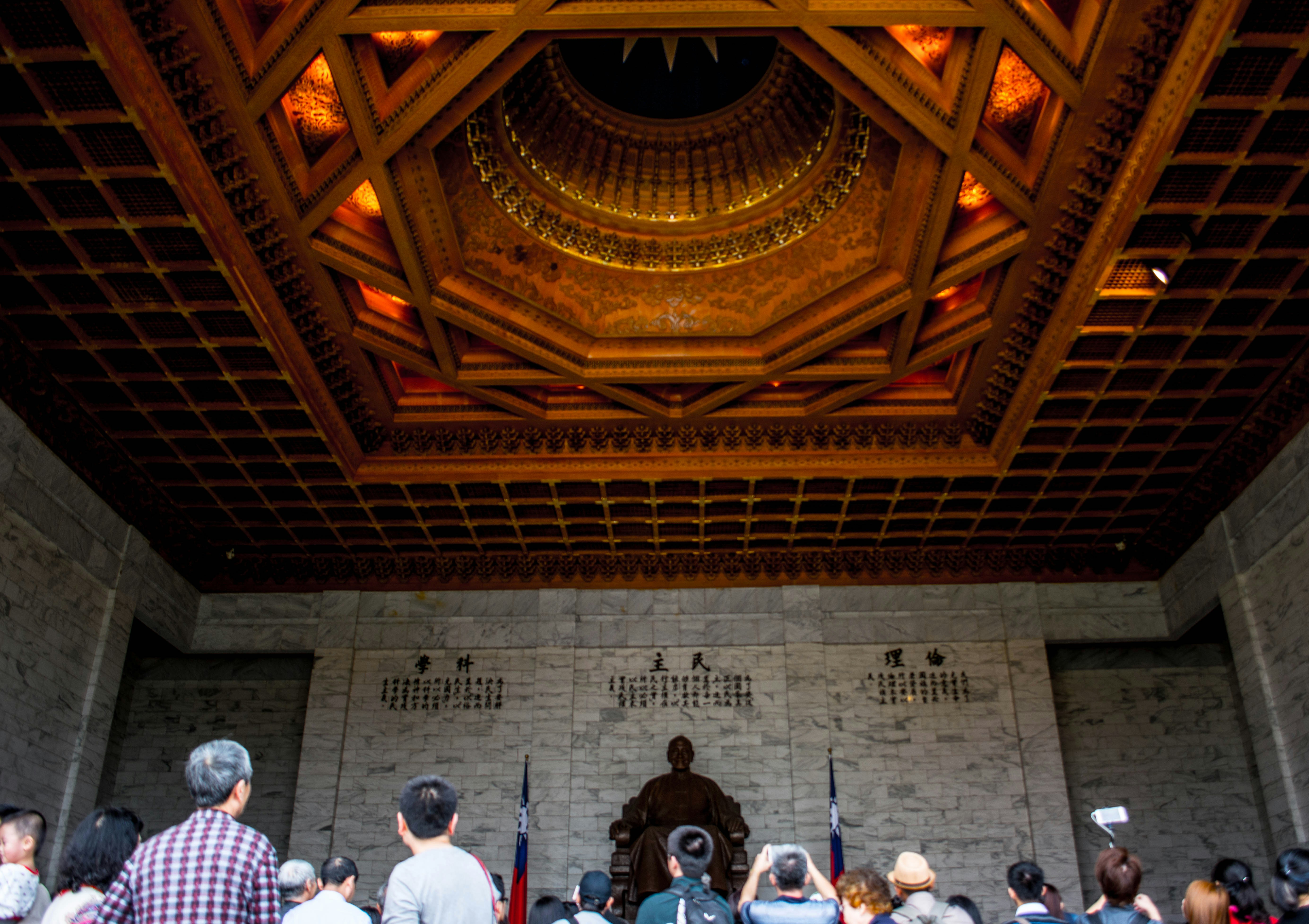Courtyard of Echoes: Visitors Gazing Up at an Intricate Coffered Ceiling