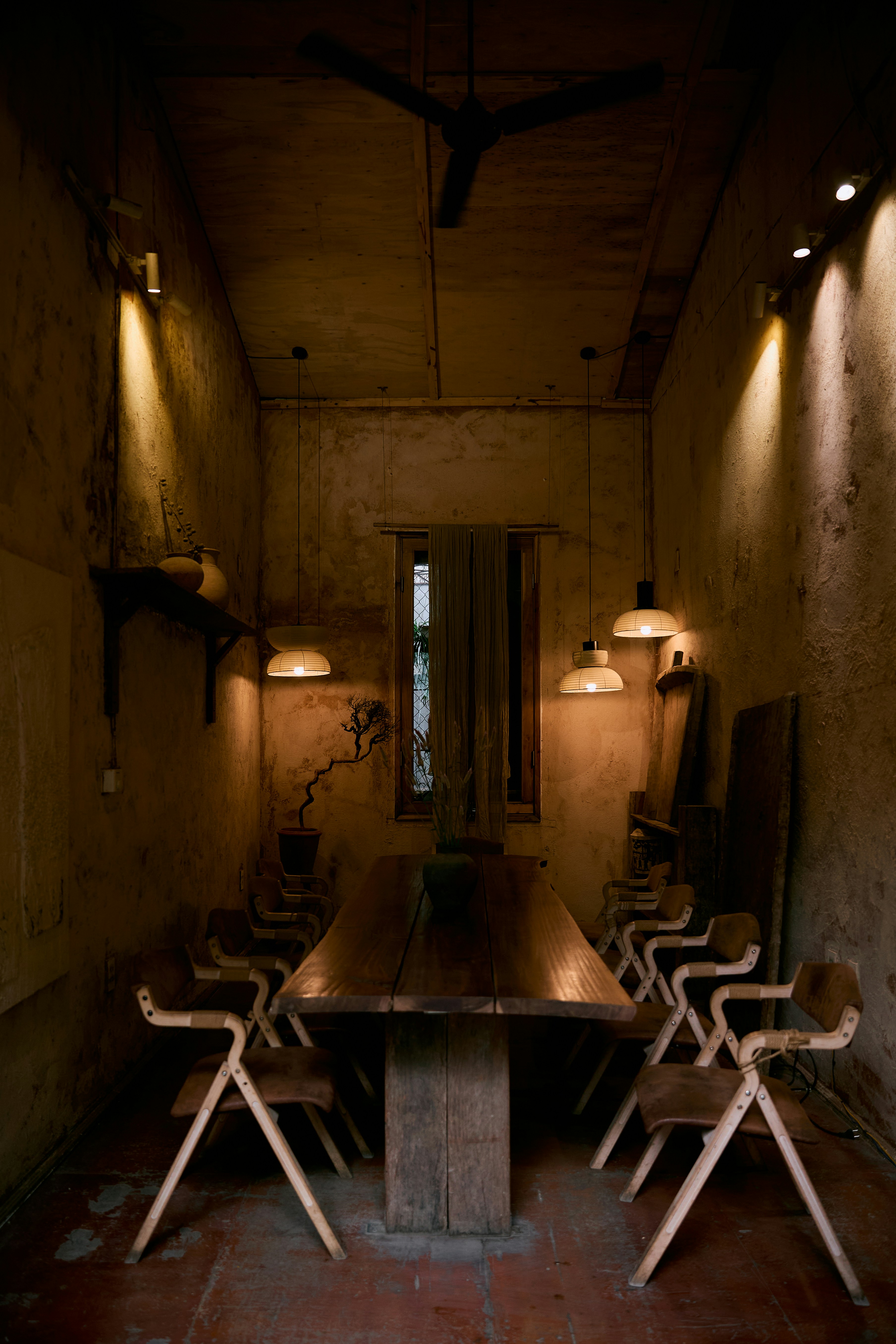 Dimly Lit Dining Hall: A Long Wooden Table in an Industrial Room