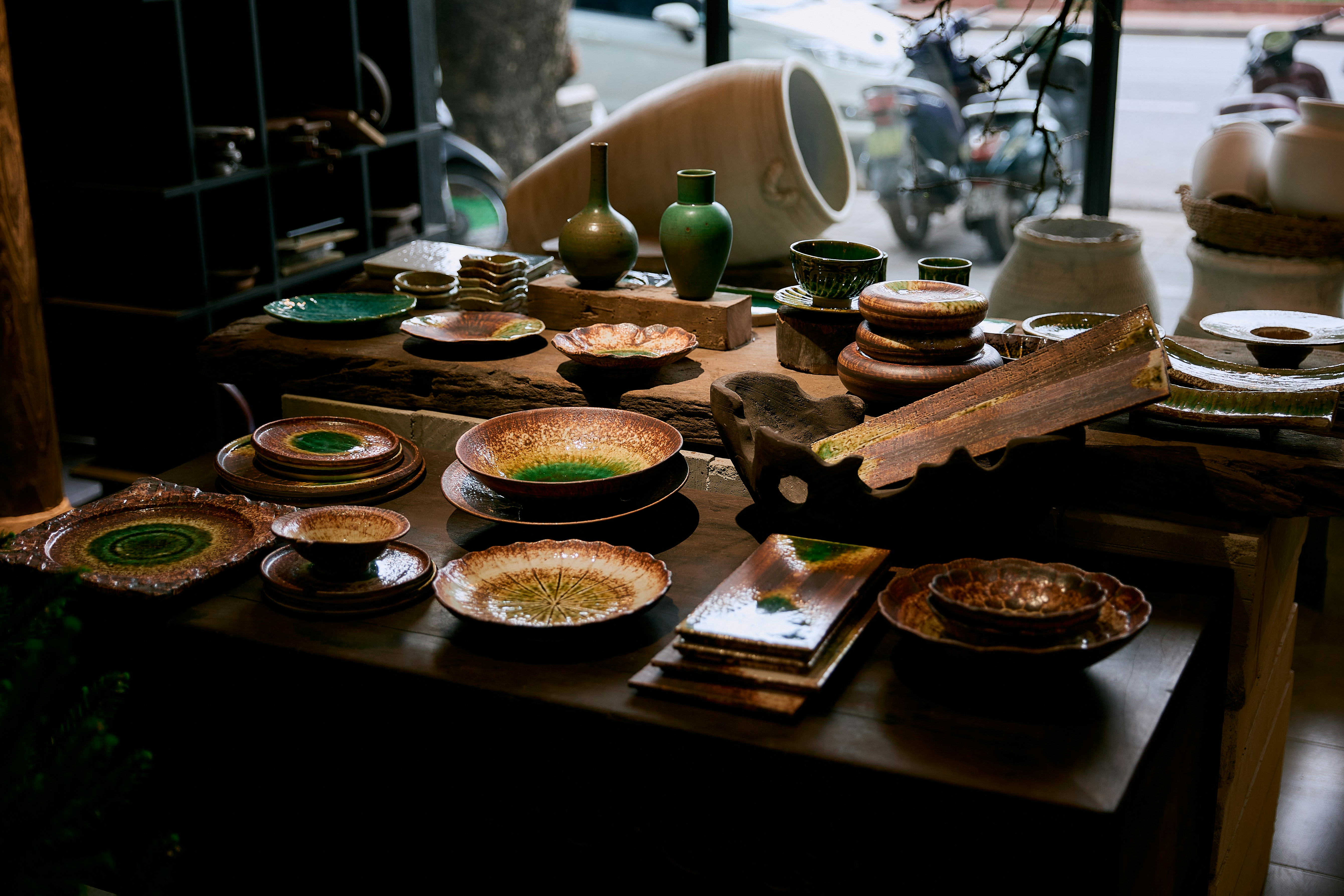 Still Life of Handcrafted Ceramics on a Sunlit Wooden Table
