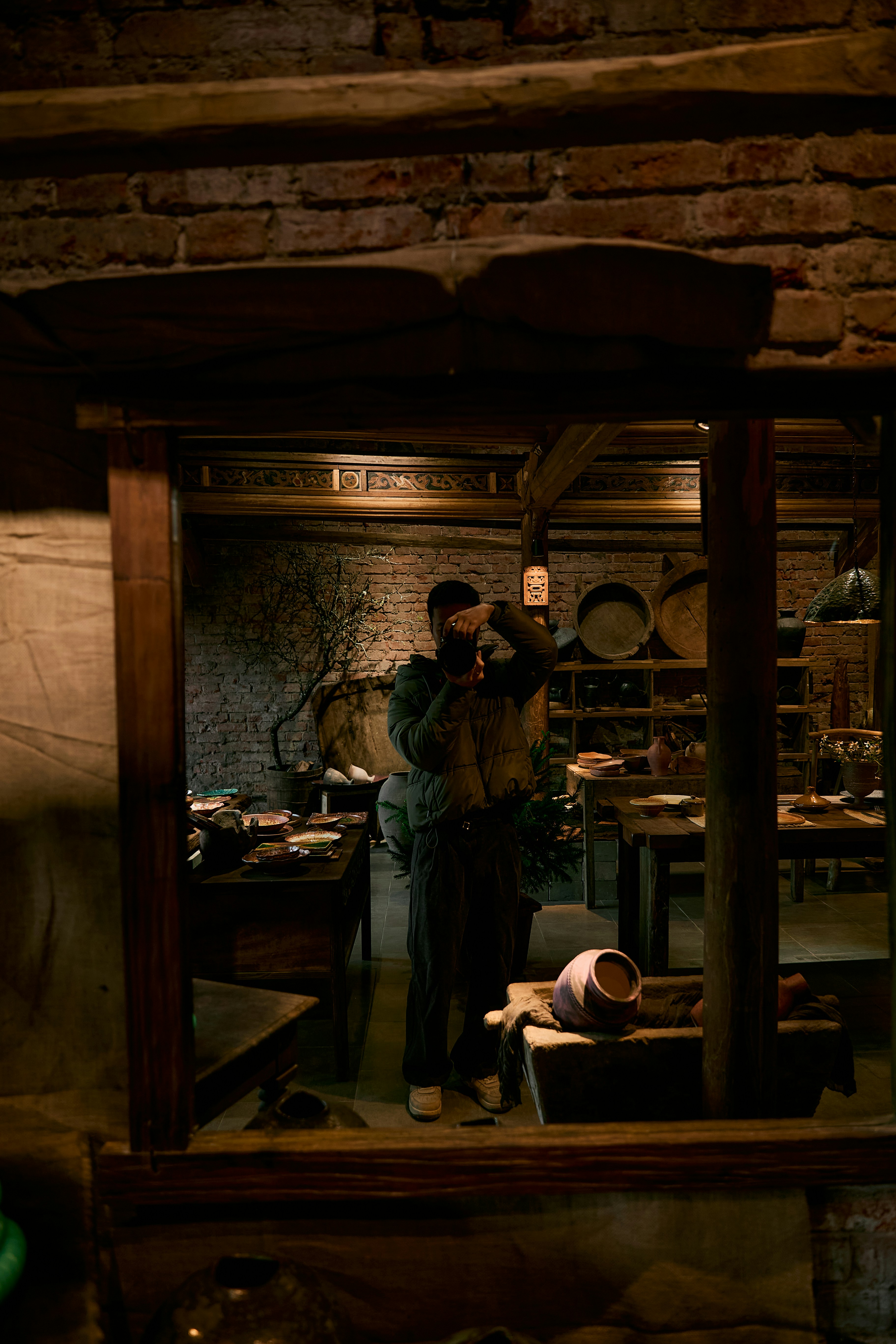 Self-portrait in a rustic eatery: a photographer mirrored by brick and wood