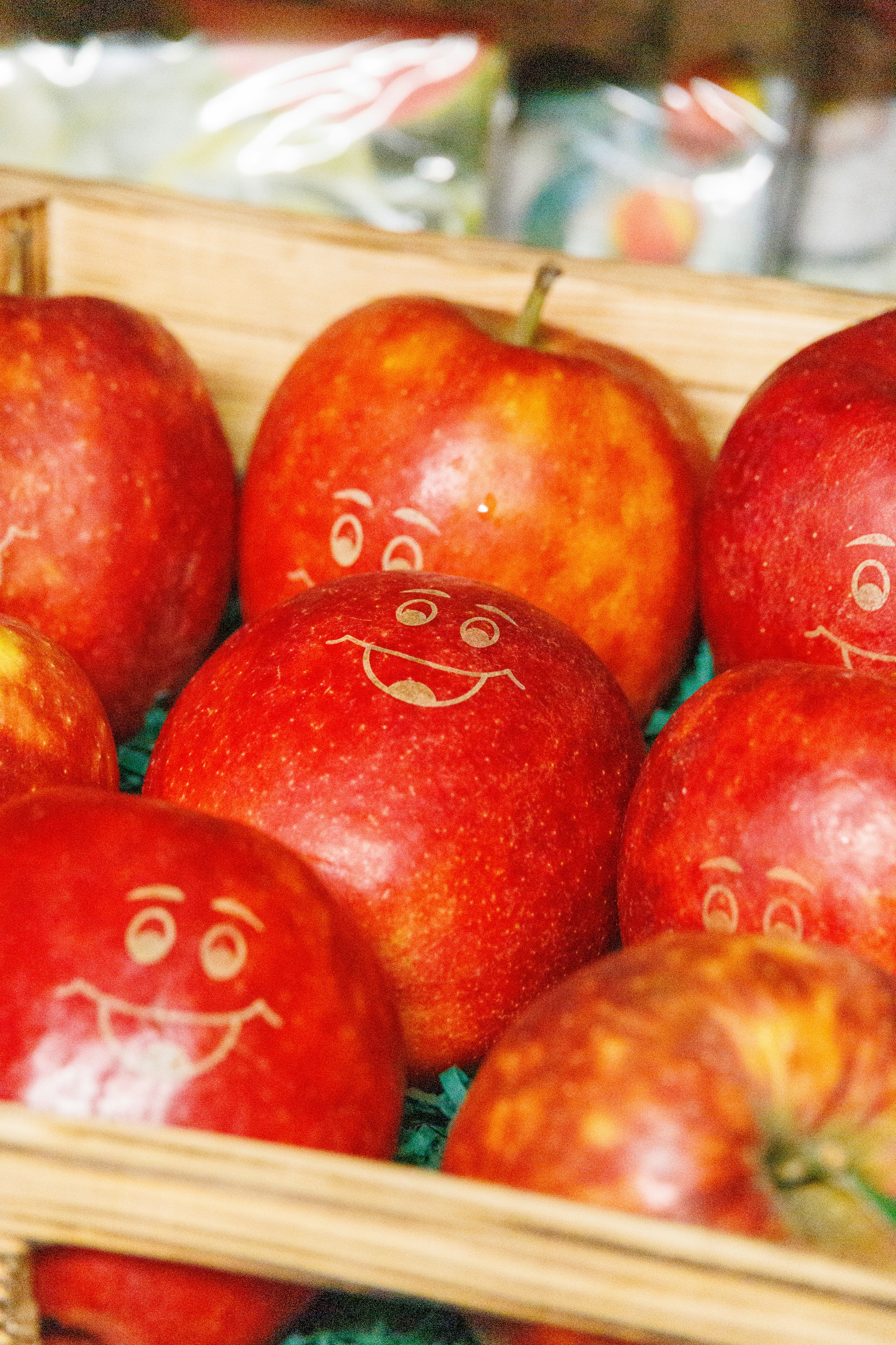 Smiling red apples in a rustic fruit crate