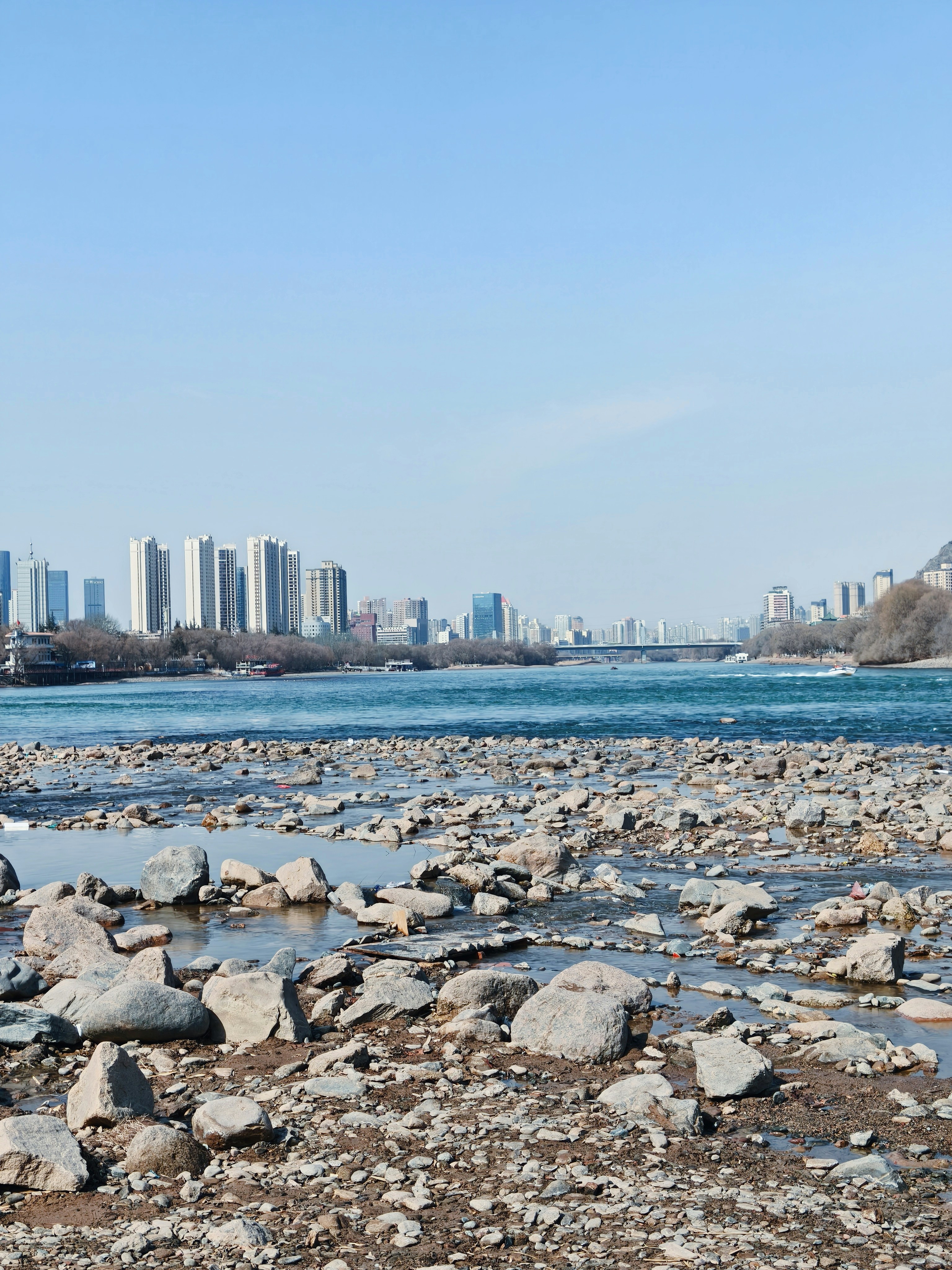 Rocky riverbed with city skyline in the distance