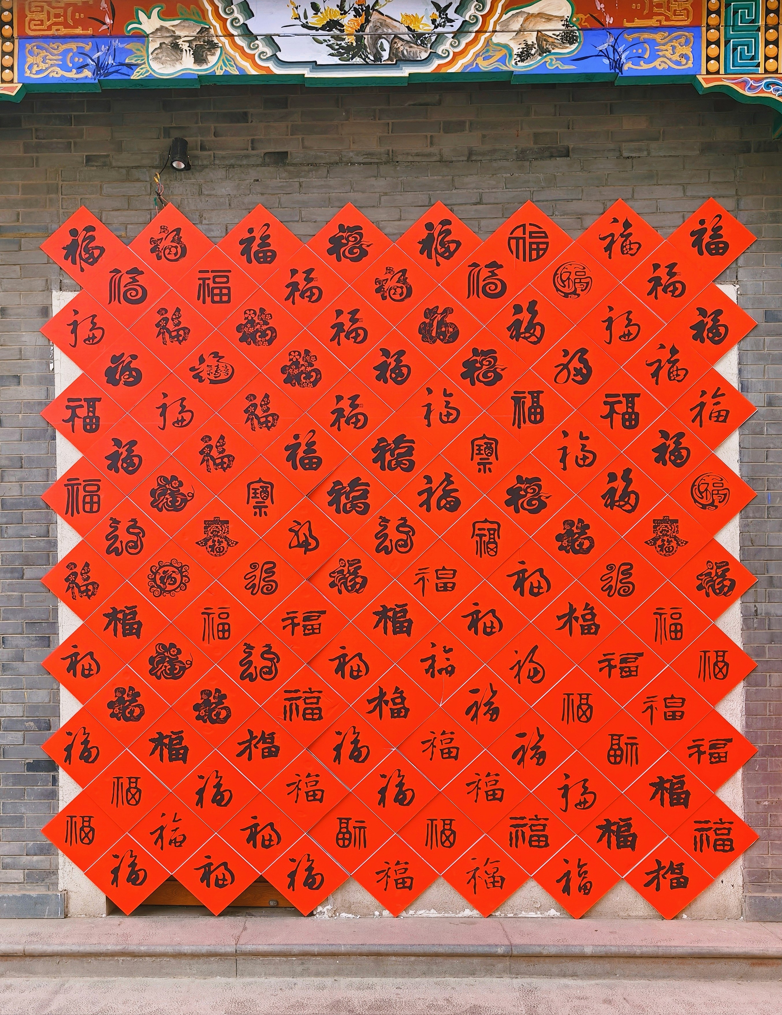 Wall decorated with many red squares with chinese characters.