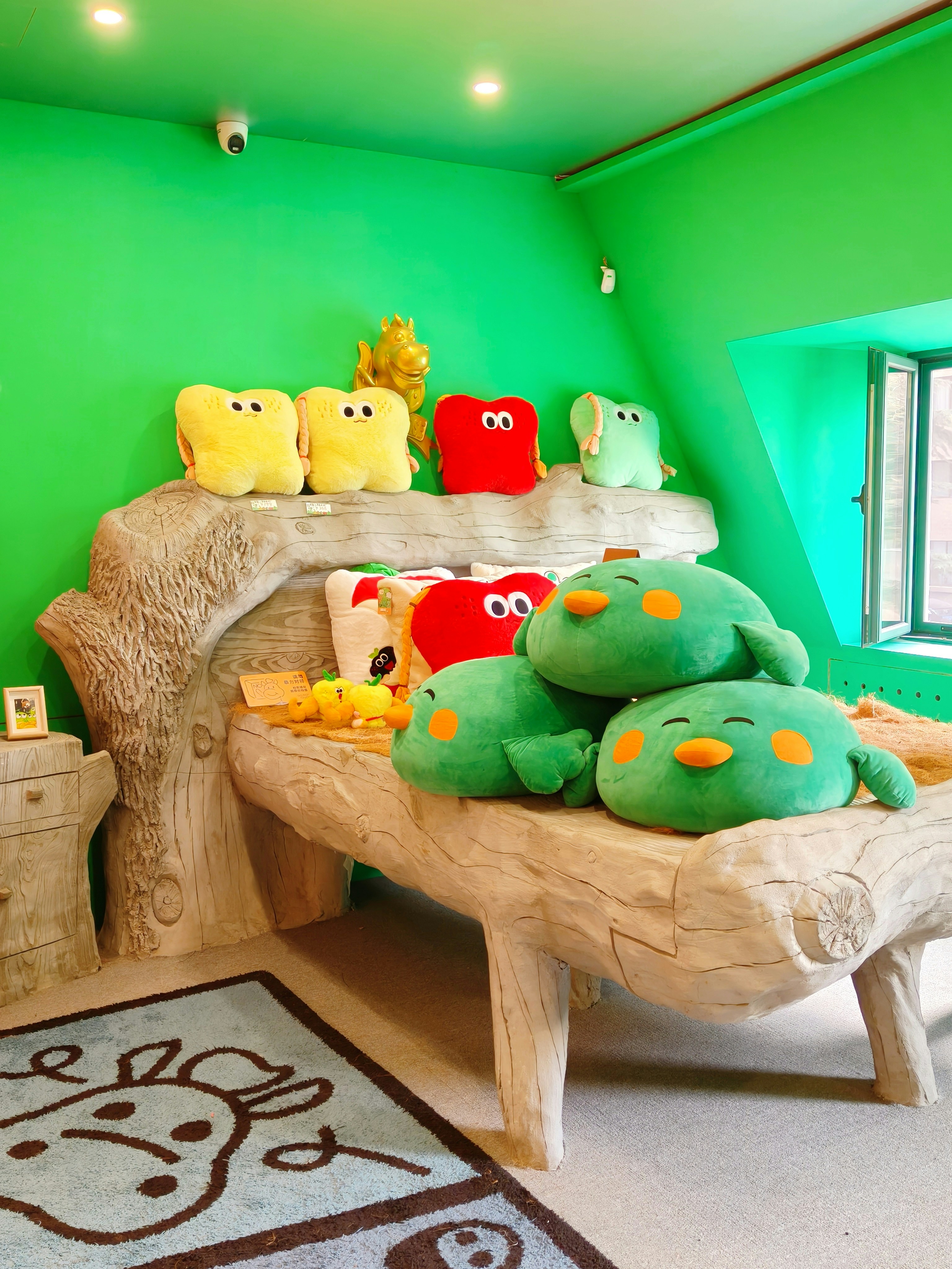 Green room with stuffed animal toys on a wooden bed.