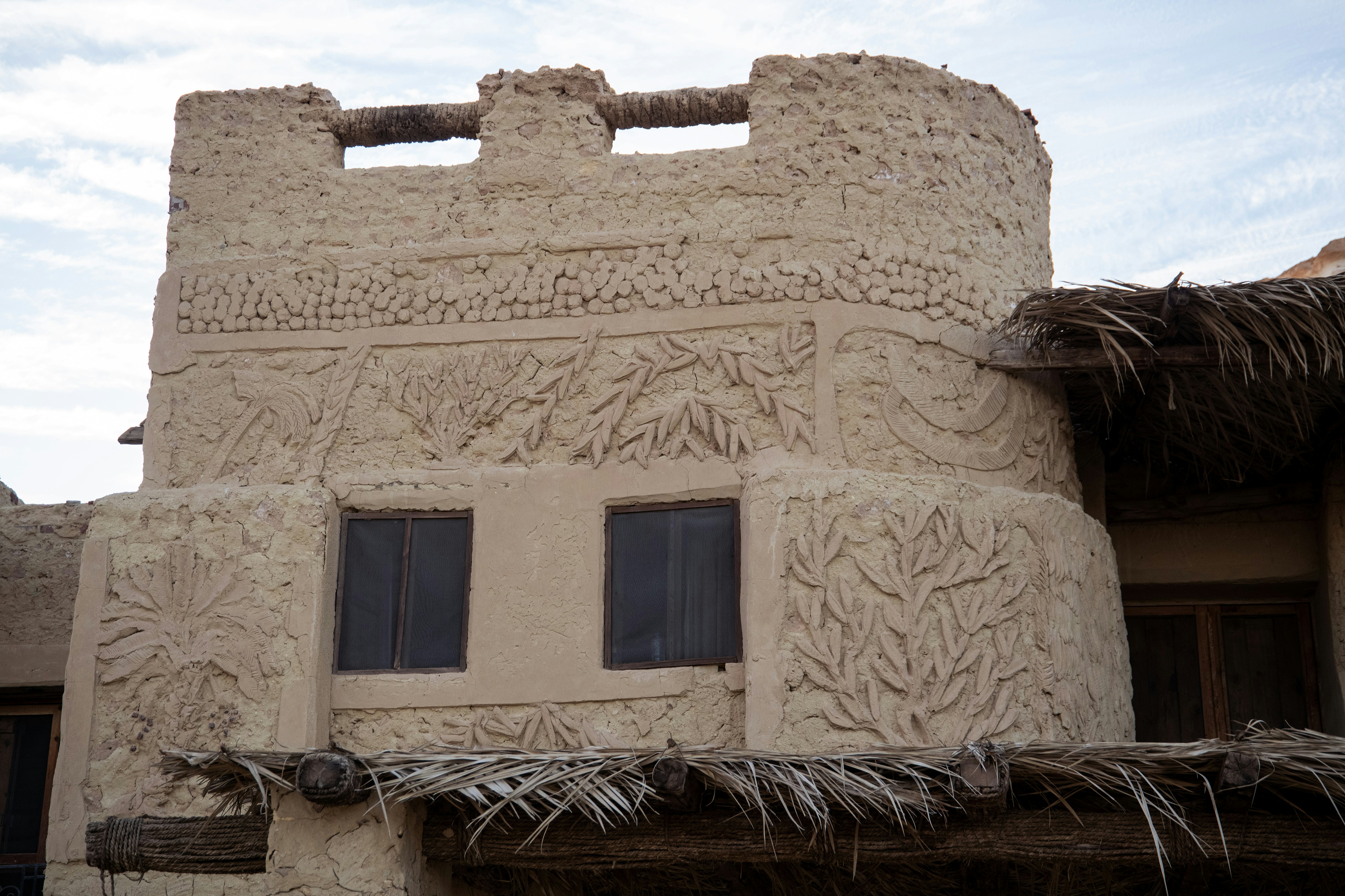 Exterior view of Taziry Ecolodge in Siwa Oasis, Egypt, built using traditional mud-brick architecture.