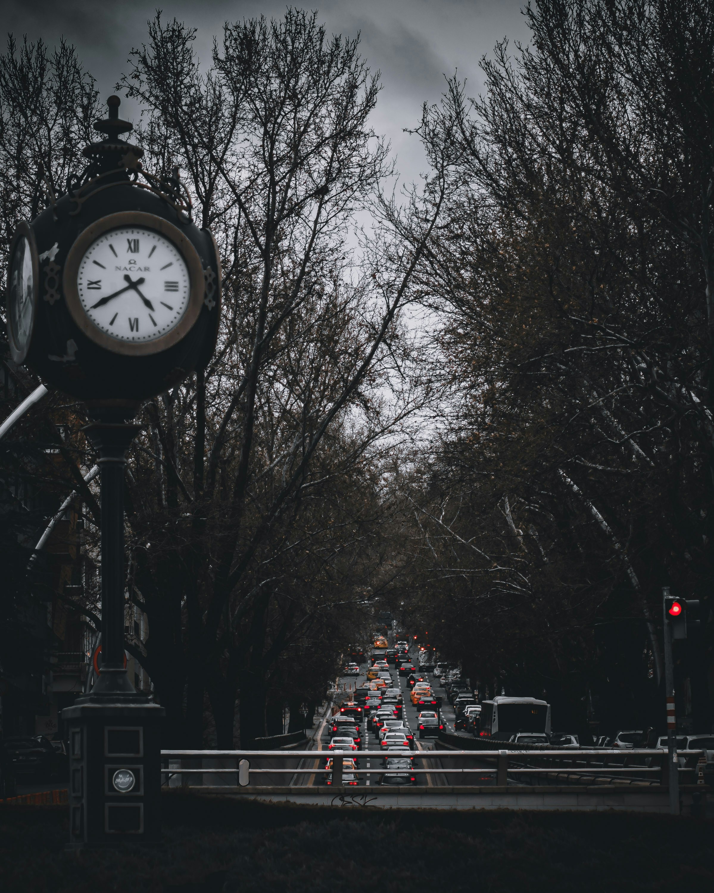 Timeless Clock Overlook: A City Awakens Through Rain and Red Lights