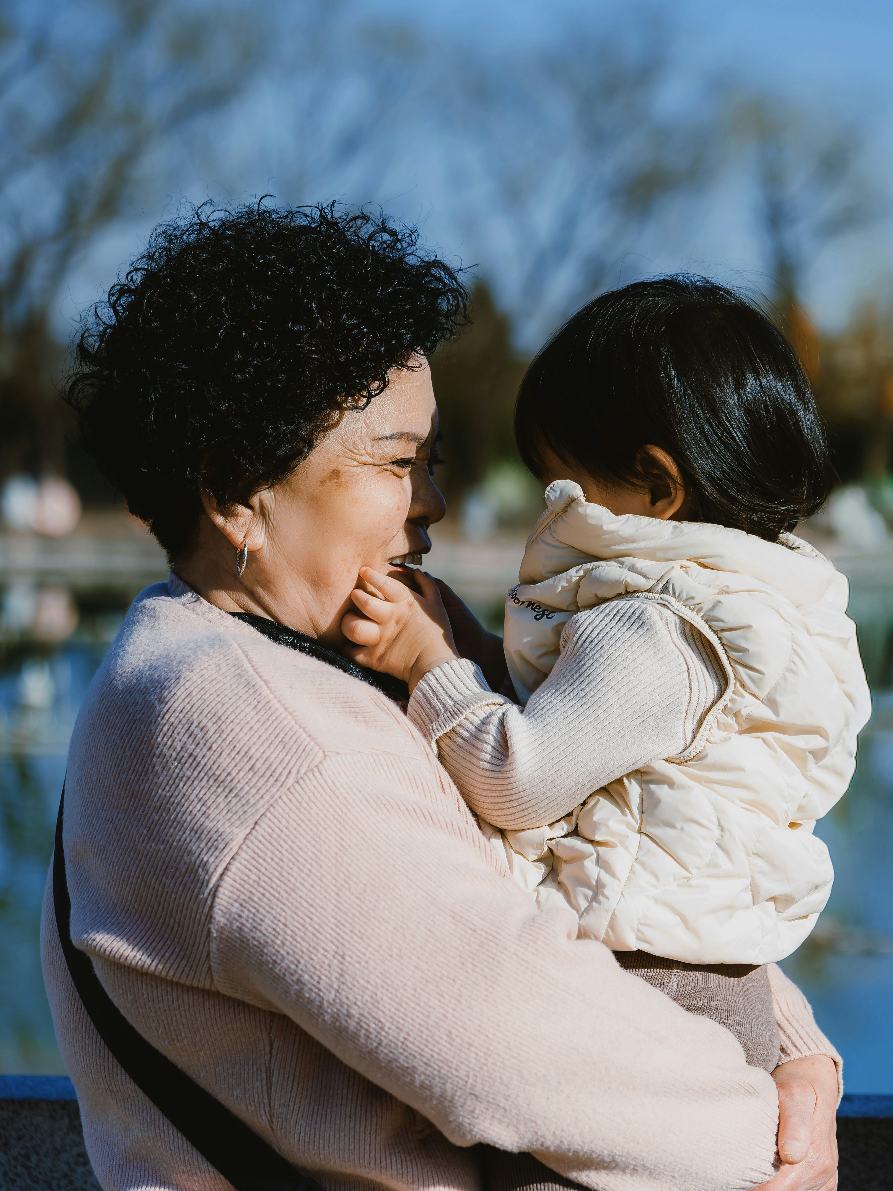 Close‑up of a grandmother and child sharing a tender moment outdoors