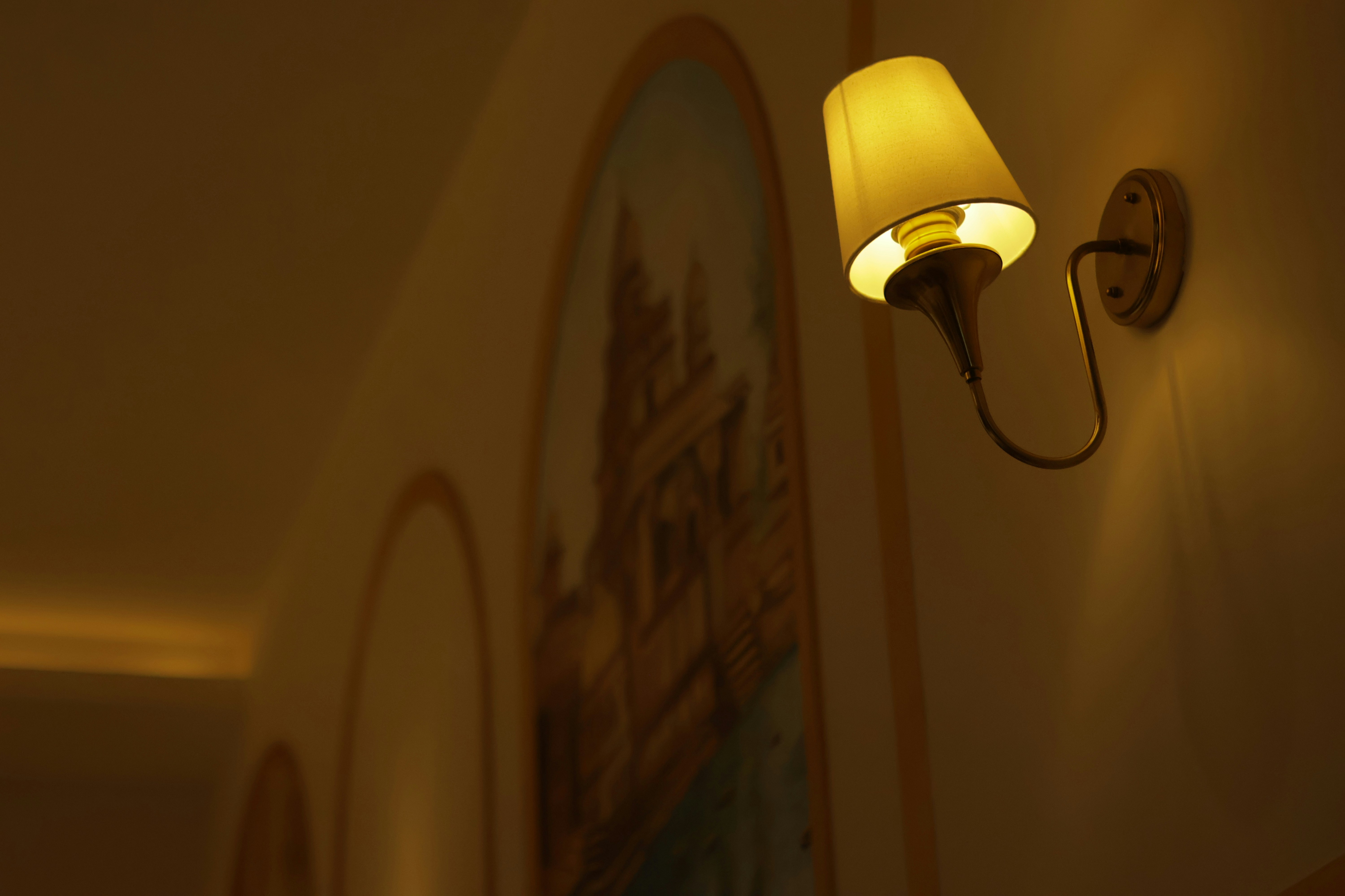 a yellow lamp on the wall of a hotel room