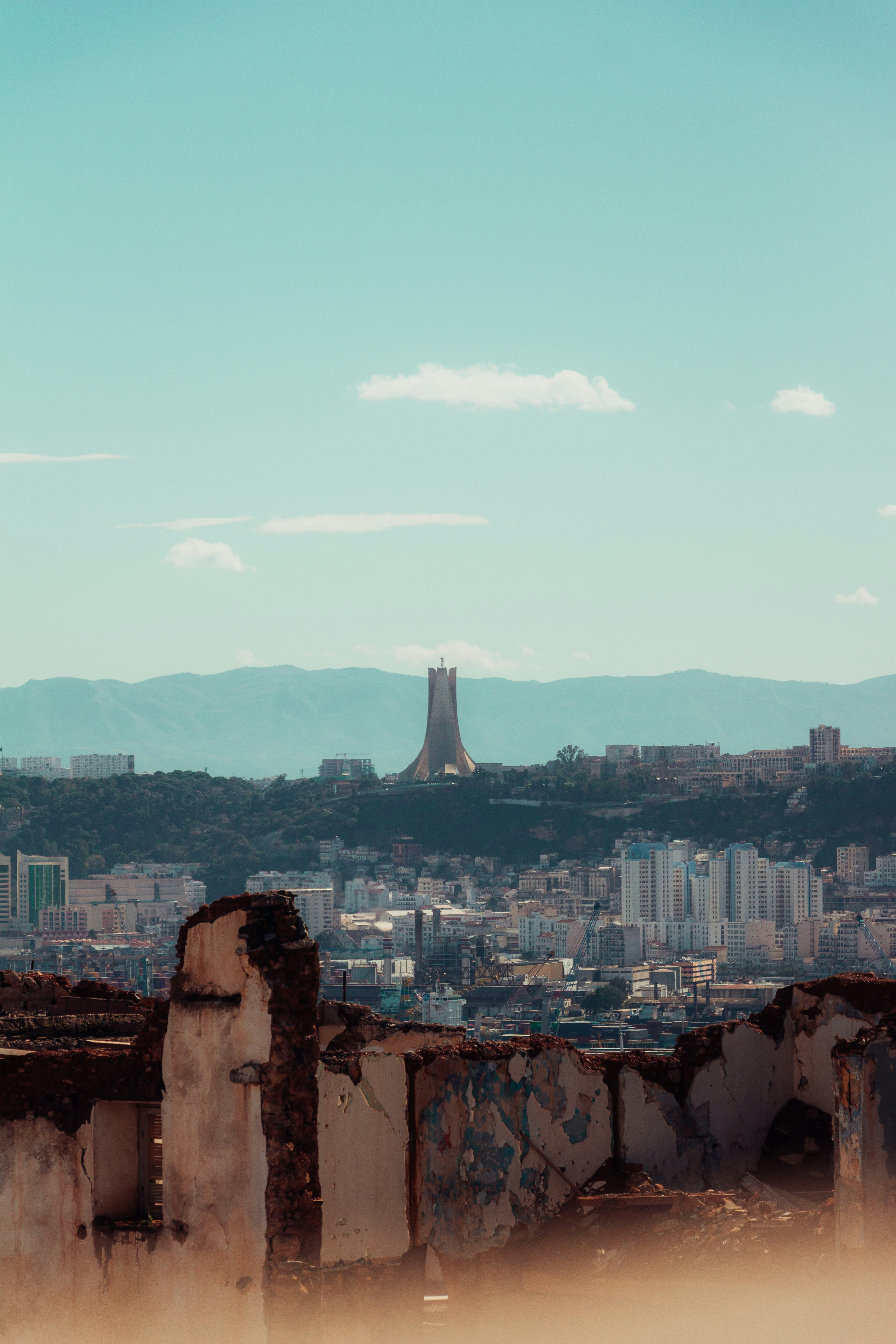 Ruins Overlook: City Skyline and Monument Rising Beyond Crumbling Walls