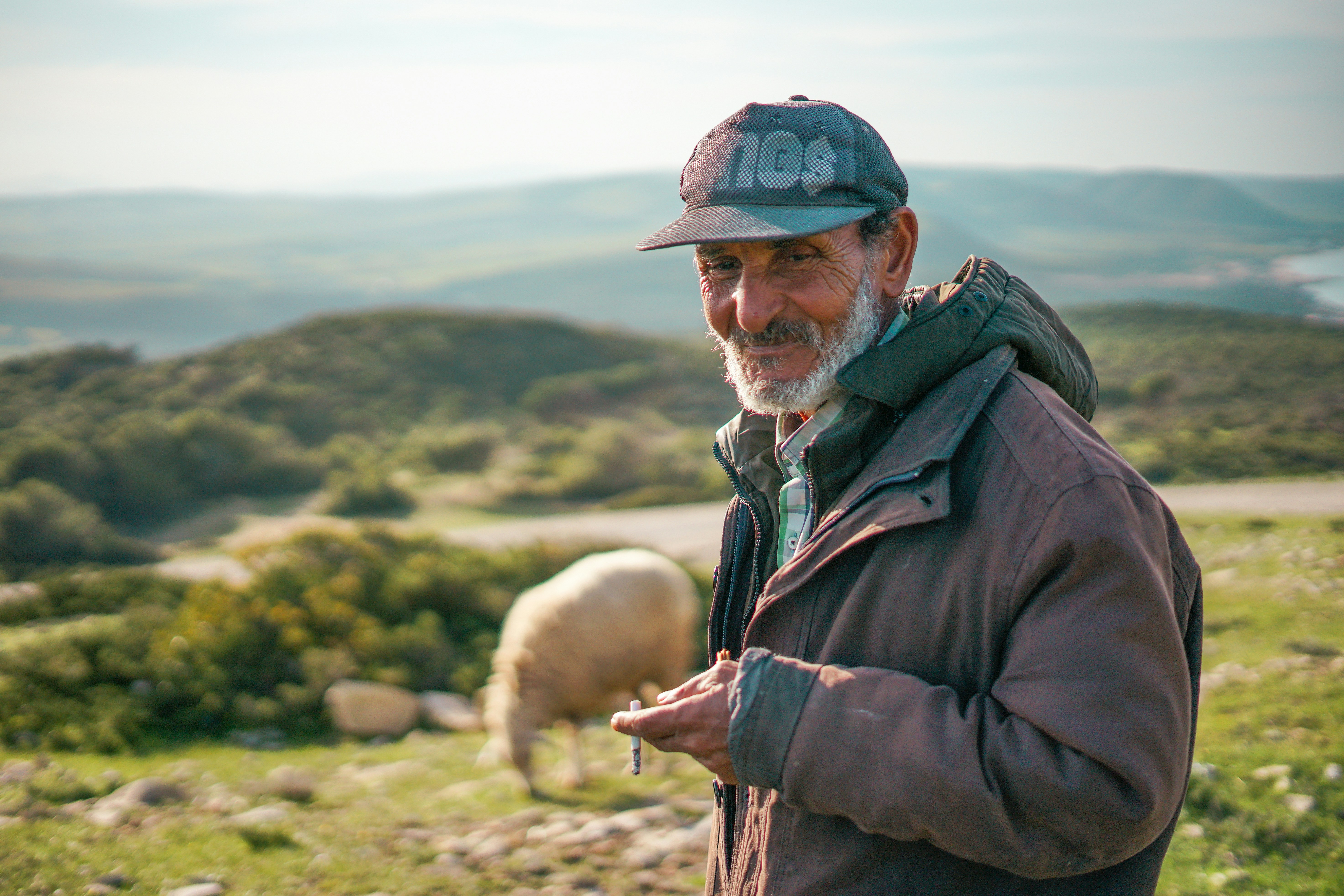 The shepherd with a weathered grin in sunlit hillside