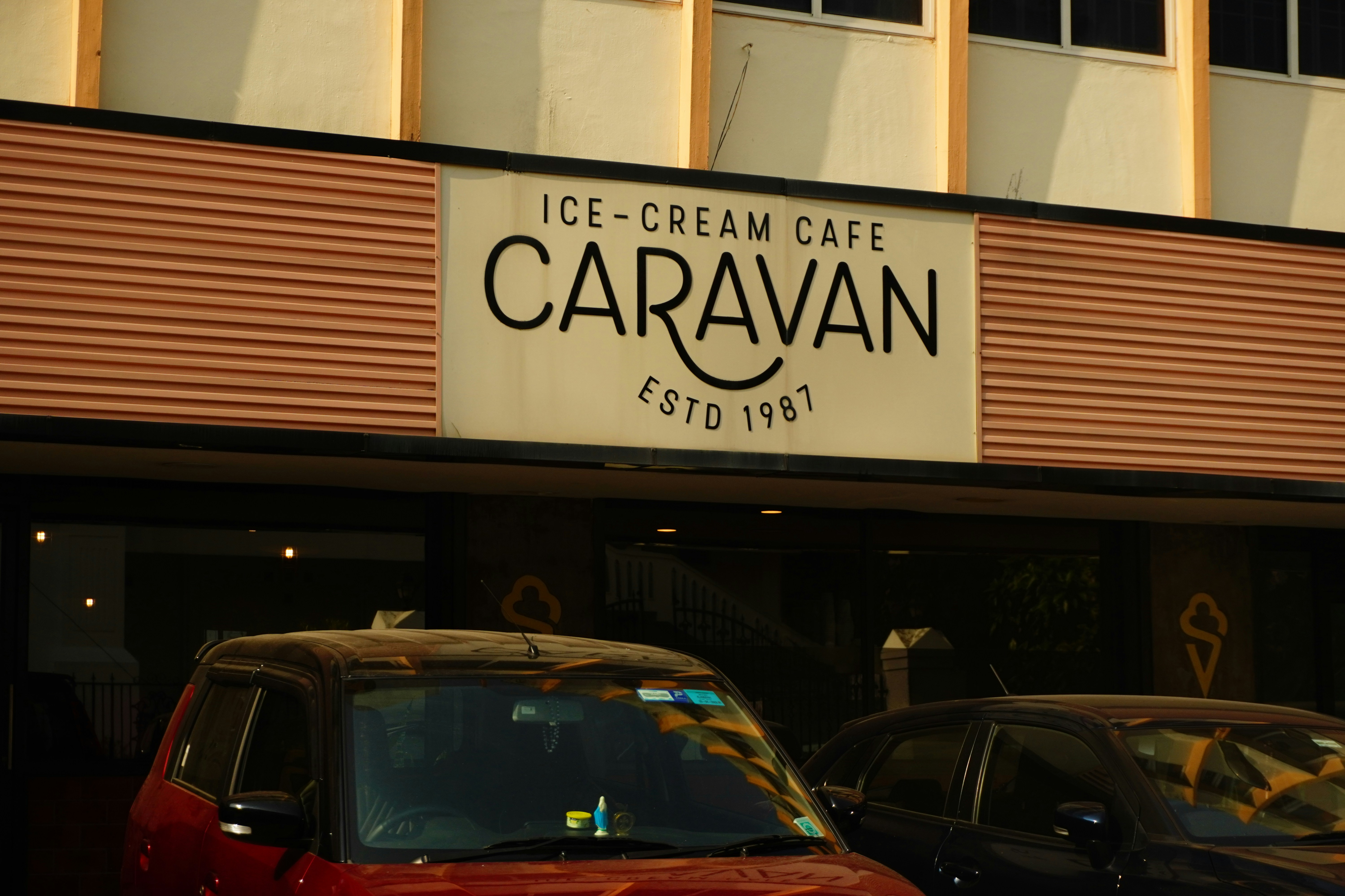 CARAVAN Ice-Cream Café Sign Above a Row of Parked Cars