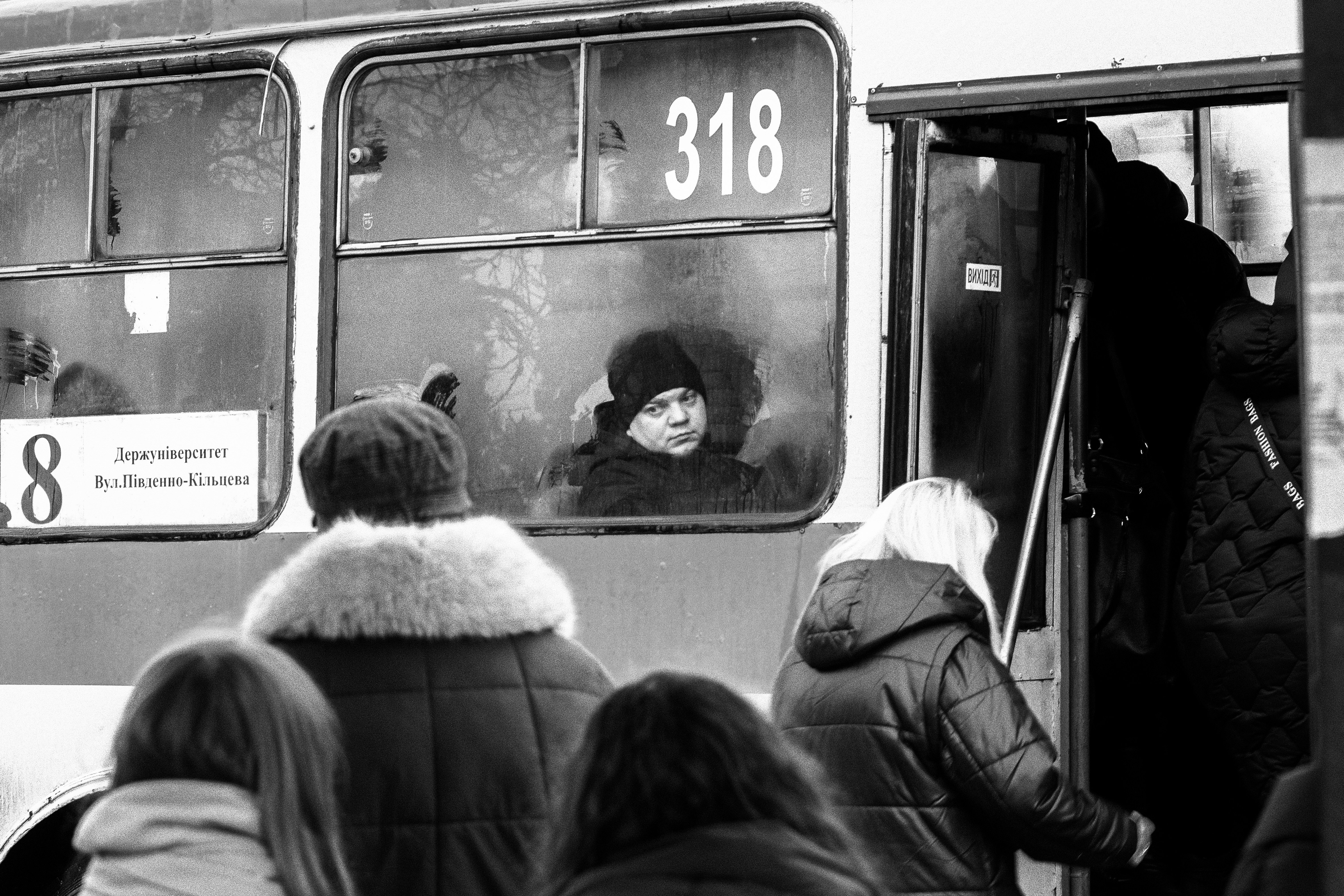 Face at the Bus Window: A Quiet Moment Against the Flow