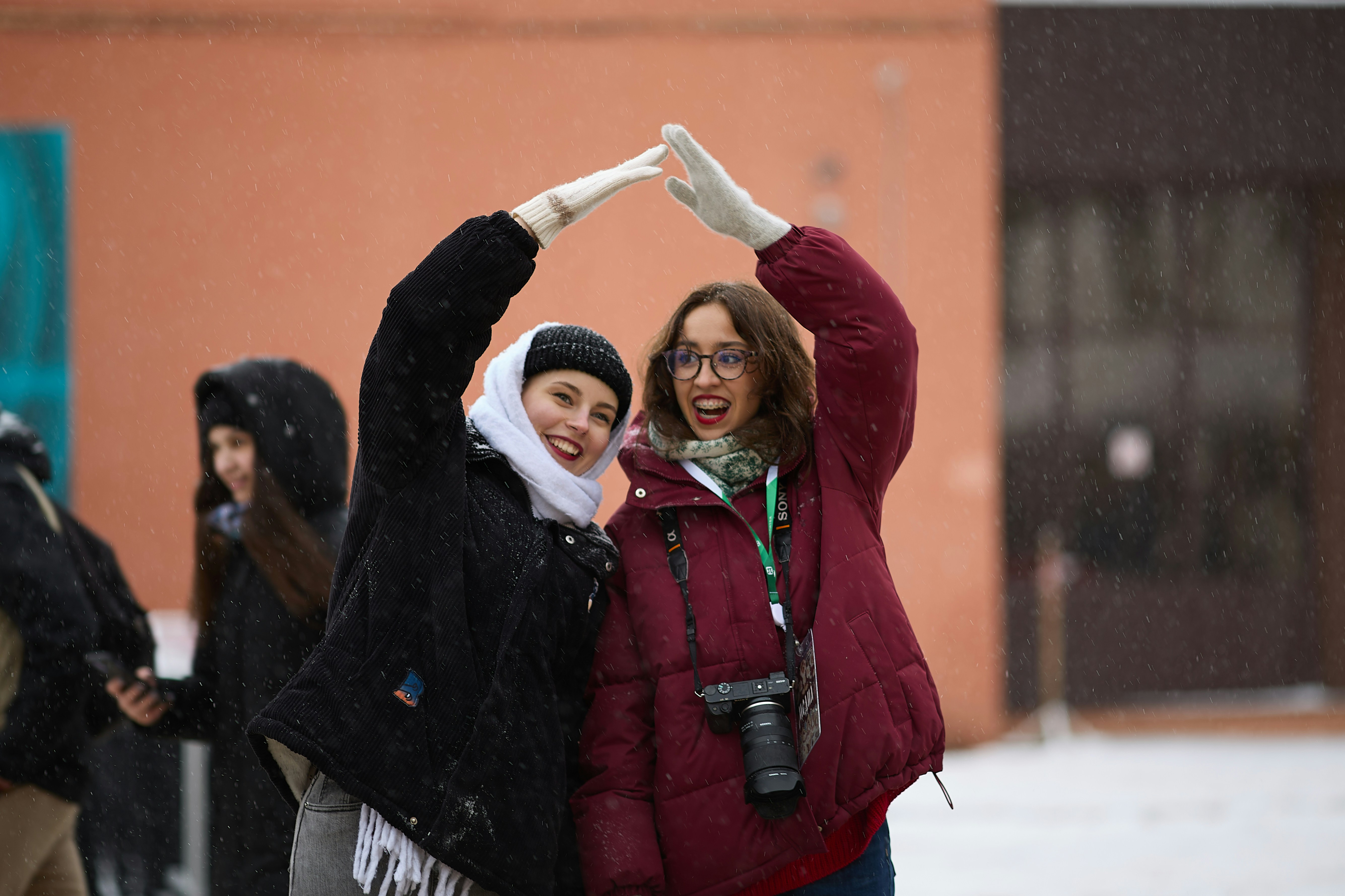 Snowy joy: friends frame a playful arc beneath falling flakes