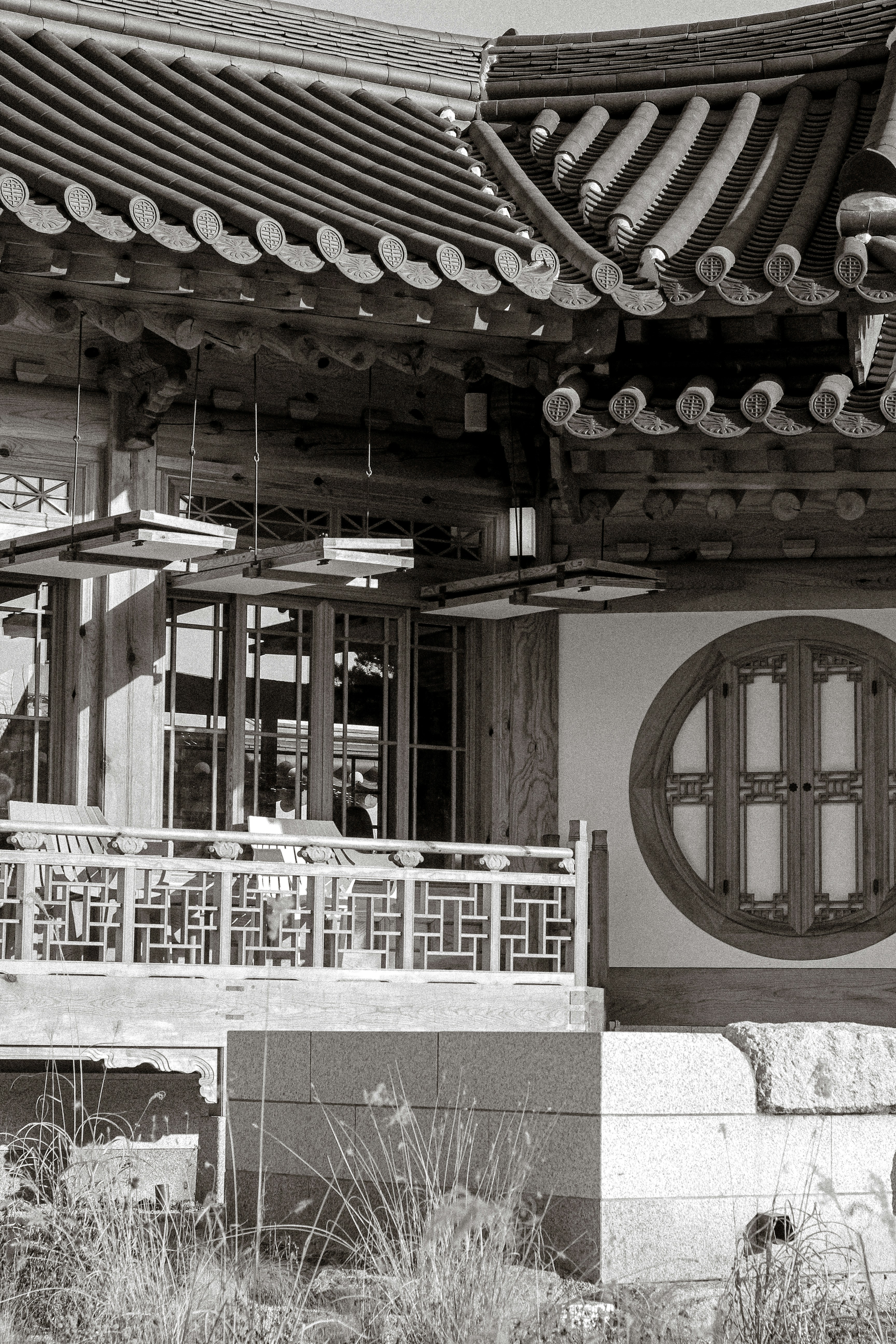Architectural Echoes: Traditional Rooflines and Circular Door in Quiet Frame