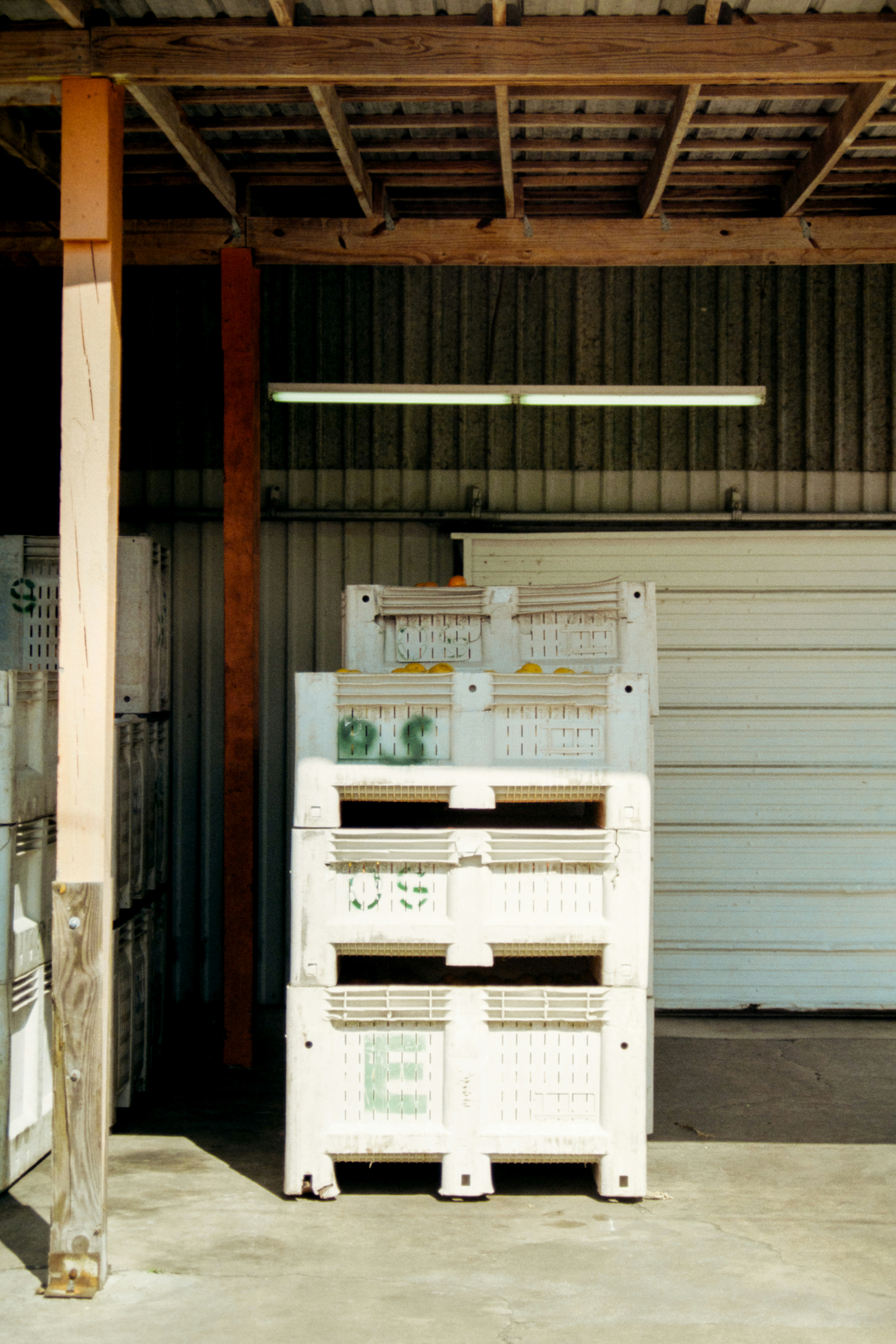 Silent Warehouse: Stacked Crates Under a Dim Overhang