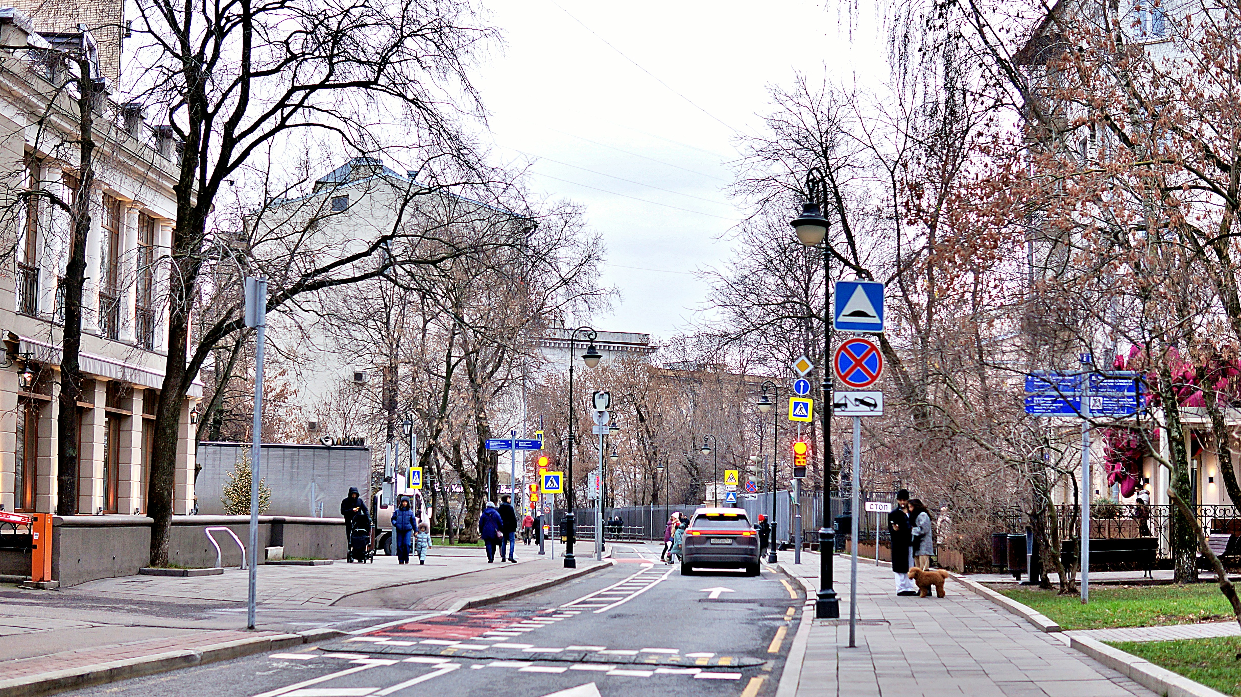 Urban Crossroads: Cars, Pedestrians, and Signage on a Winter Street