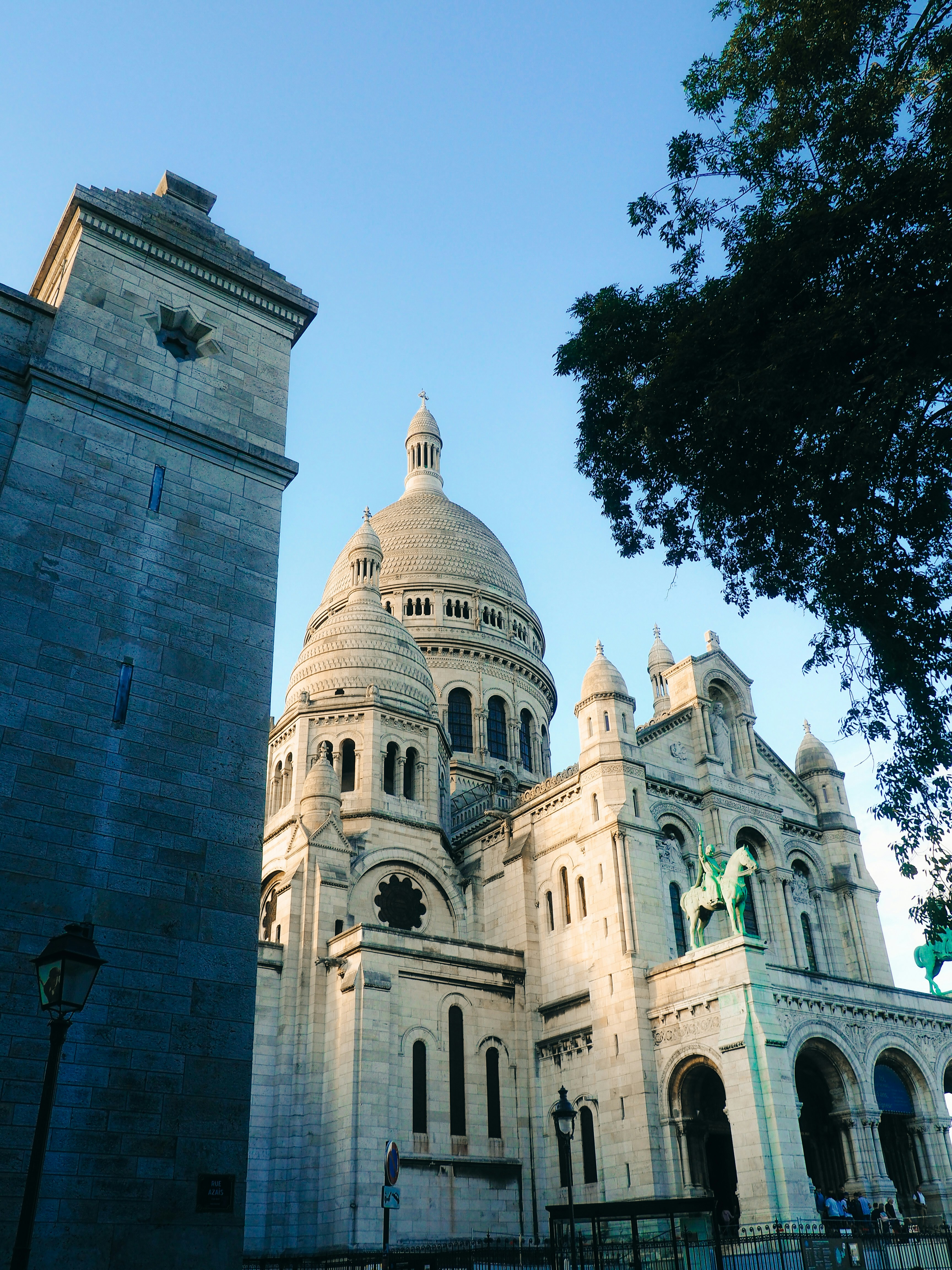 Saintly Silhouette: The Sacré-Cœur Towering Over a Stone Facade