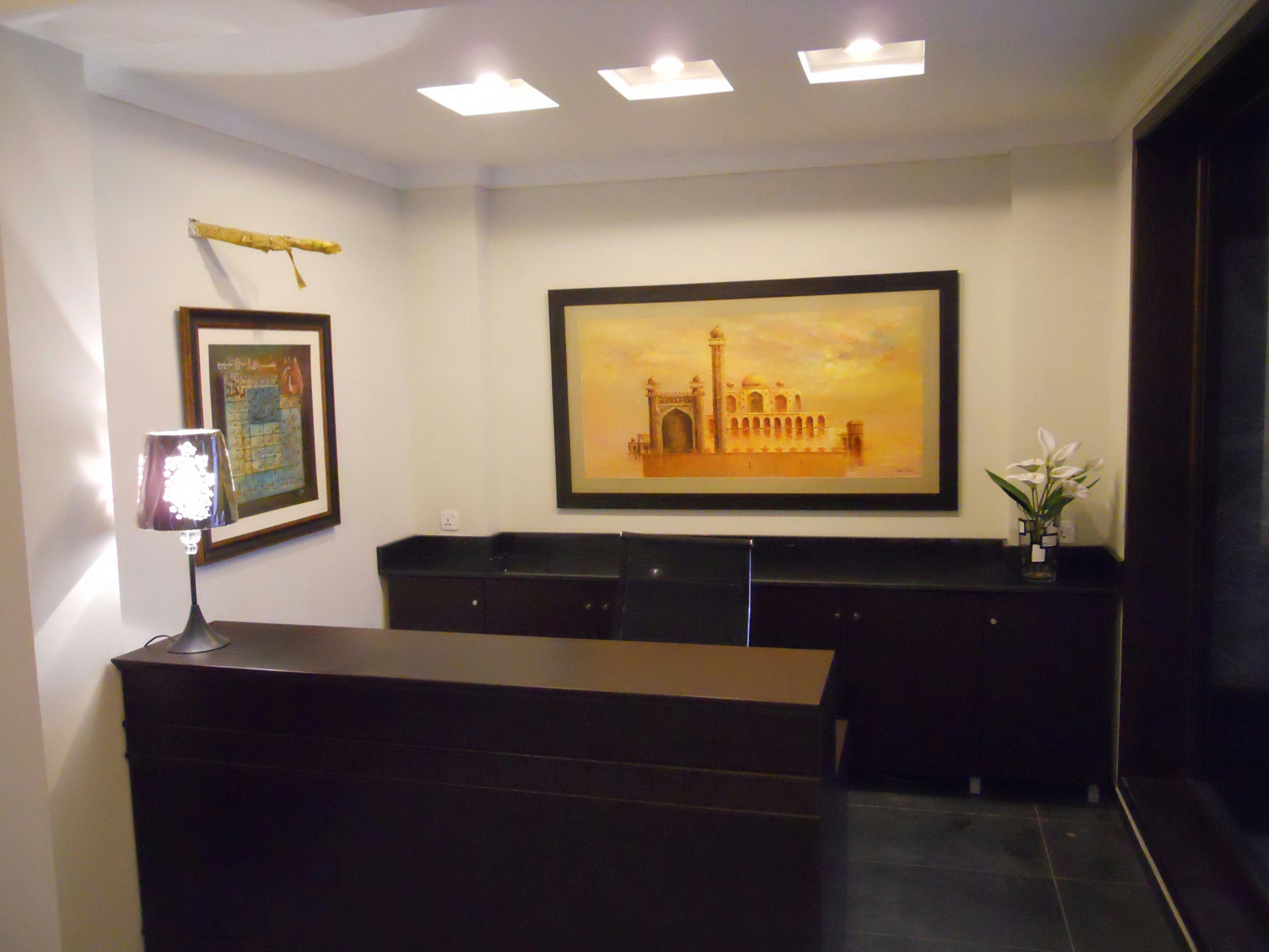 A reception desk with artwork on the wall.