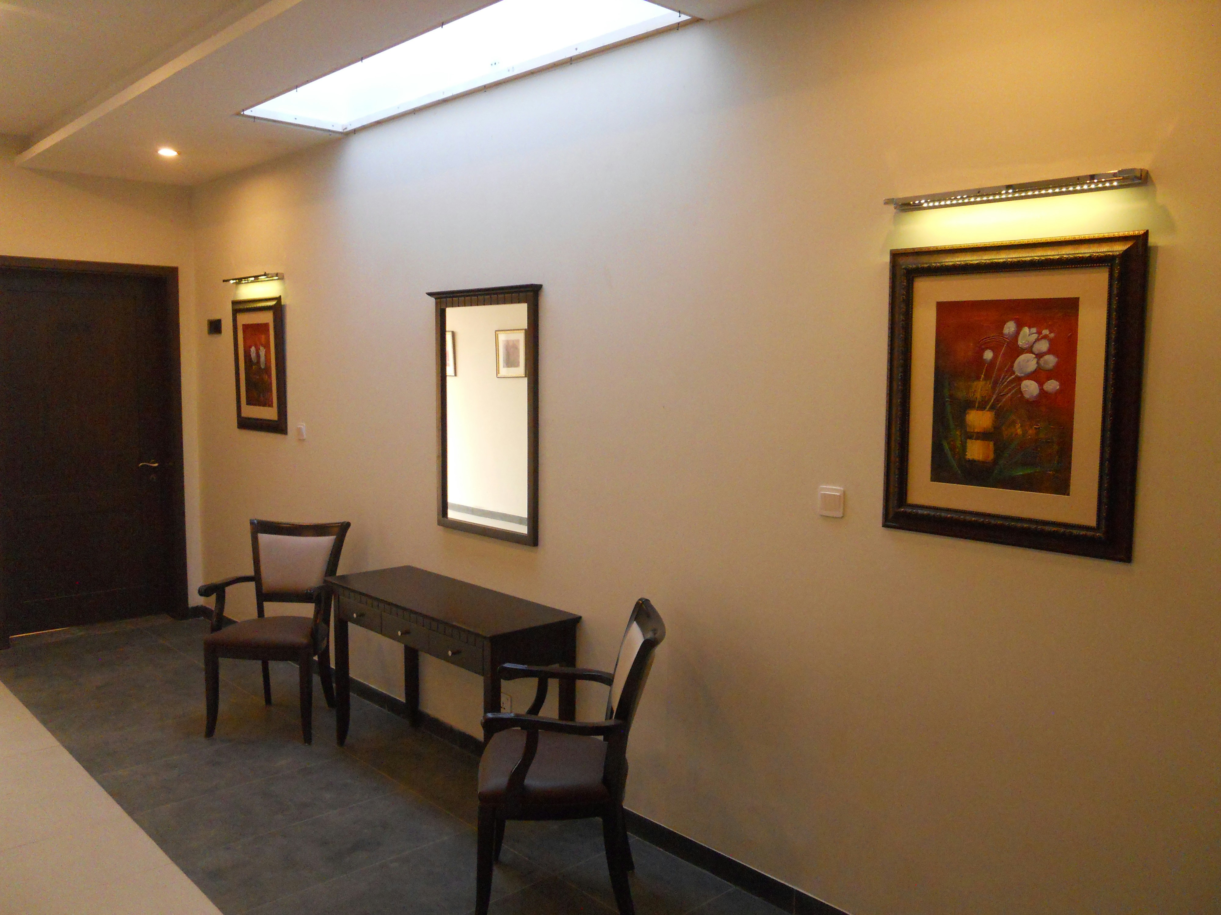 Hallway with two chairs, console table, and artwork.