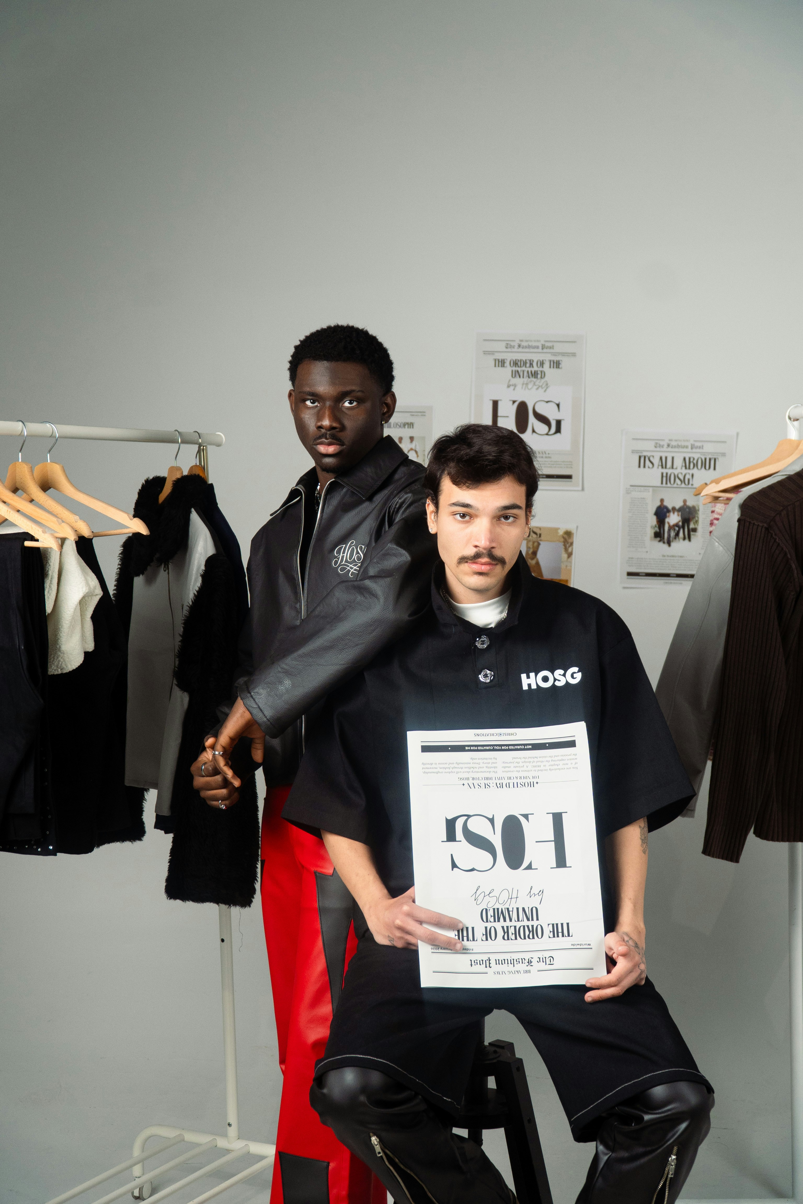 Two Models in a Backstage Wardrobe with a Printed Document